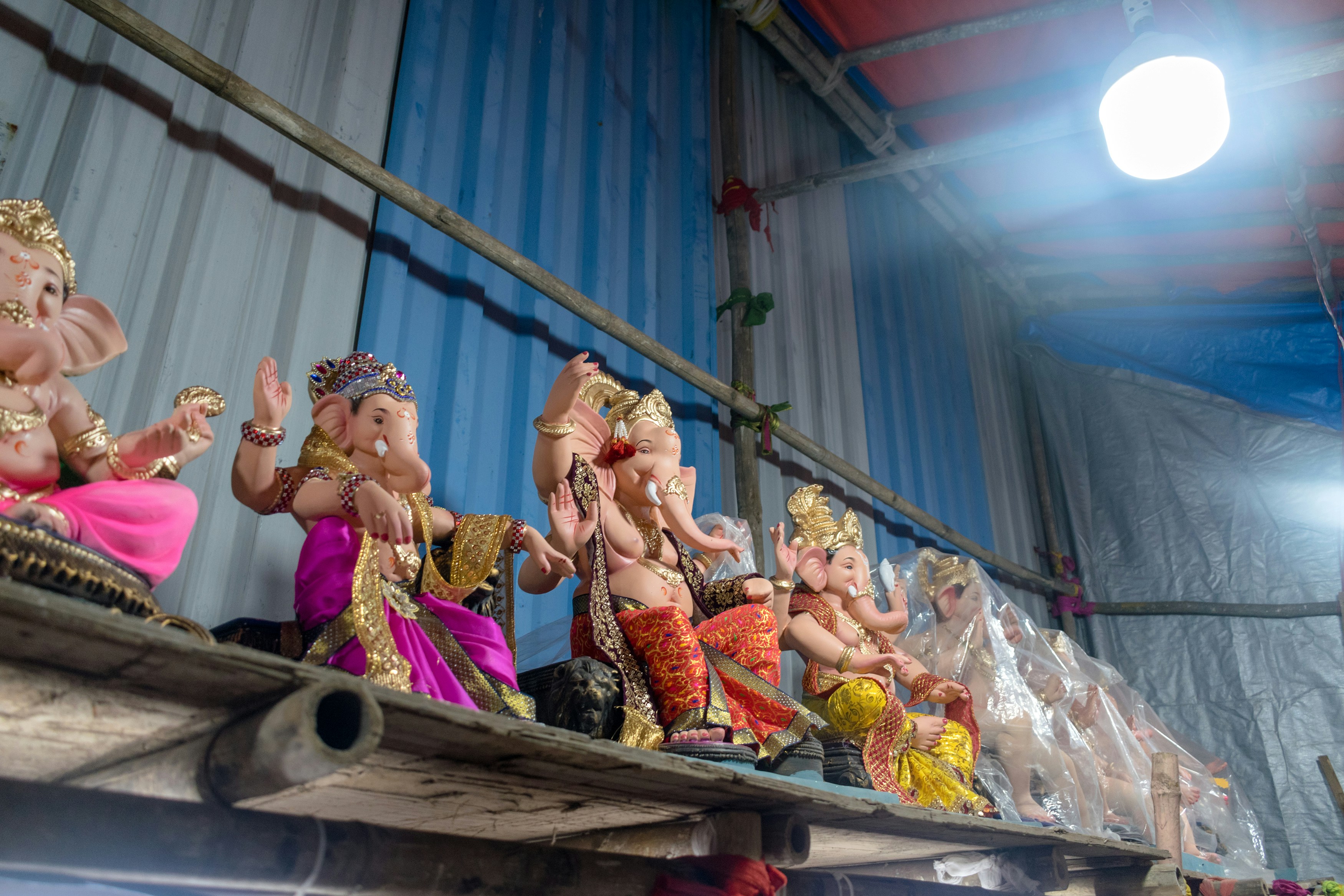 A group of small statues sitting on top of a shelf photo – Free Mumbai ...