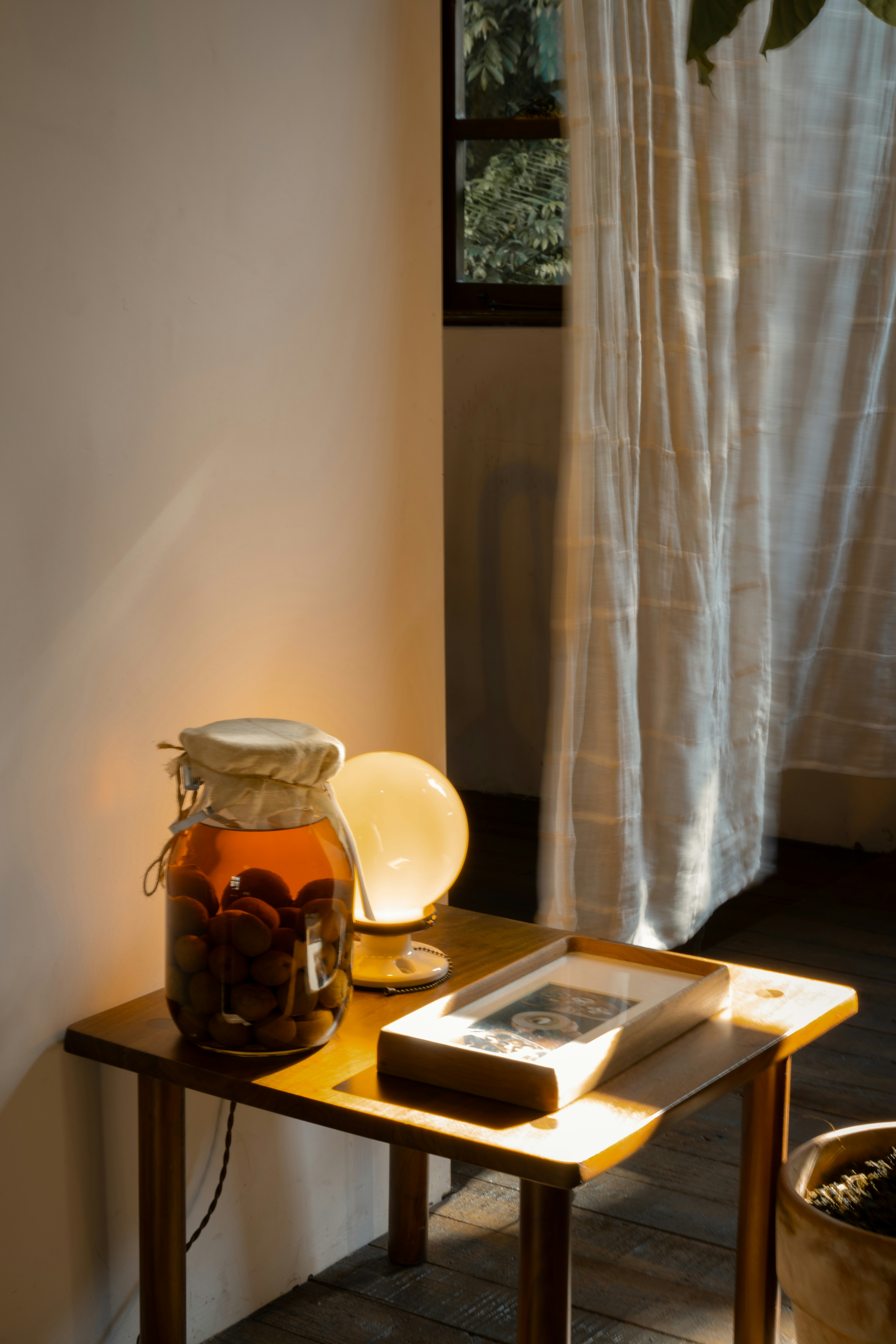 Amber Still Life Beneath a Quiet Glow: Jar, Globe, and a Framed Moment