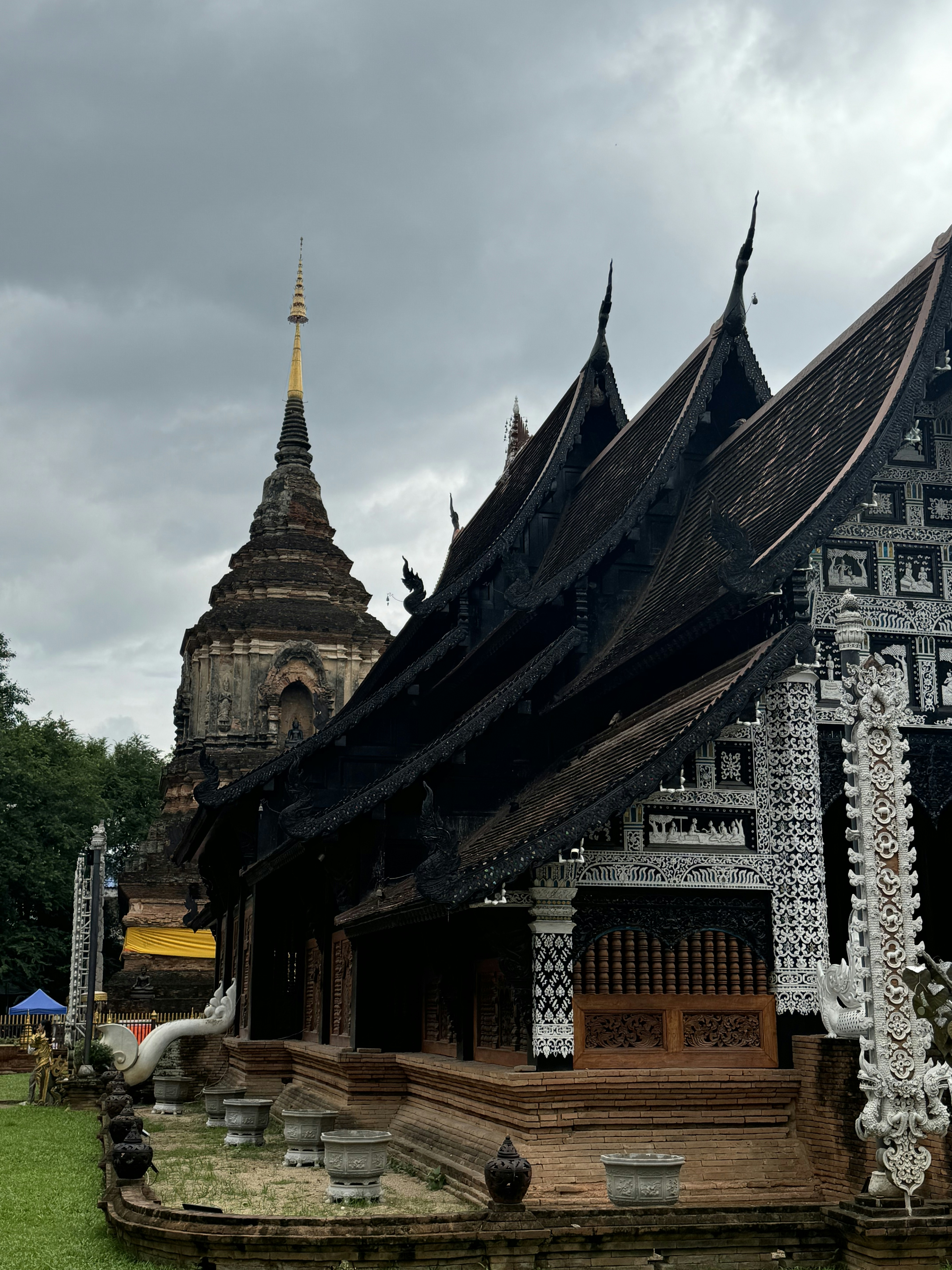 Shadowed Rooflines and a Golden Spire: A Thai-Influenced Temple Portrait