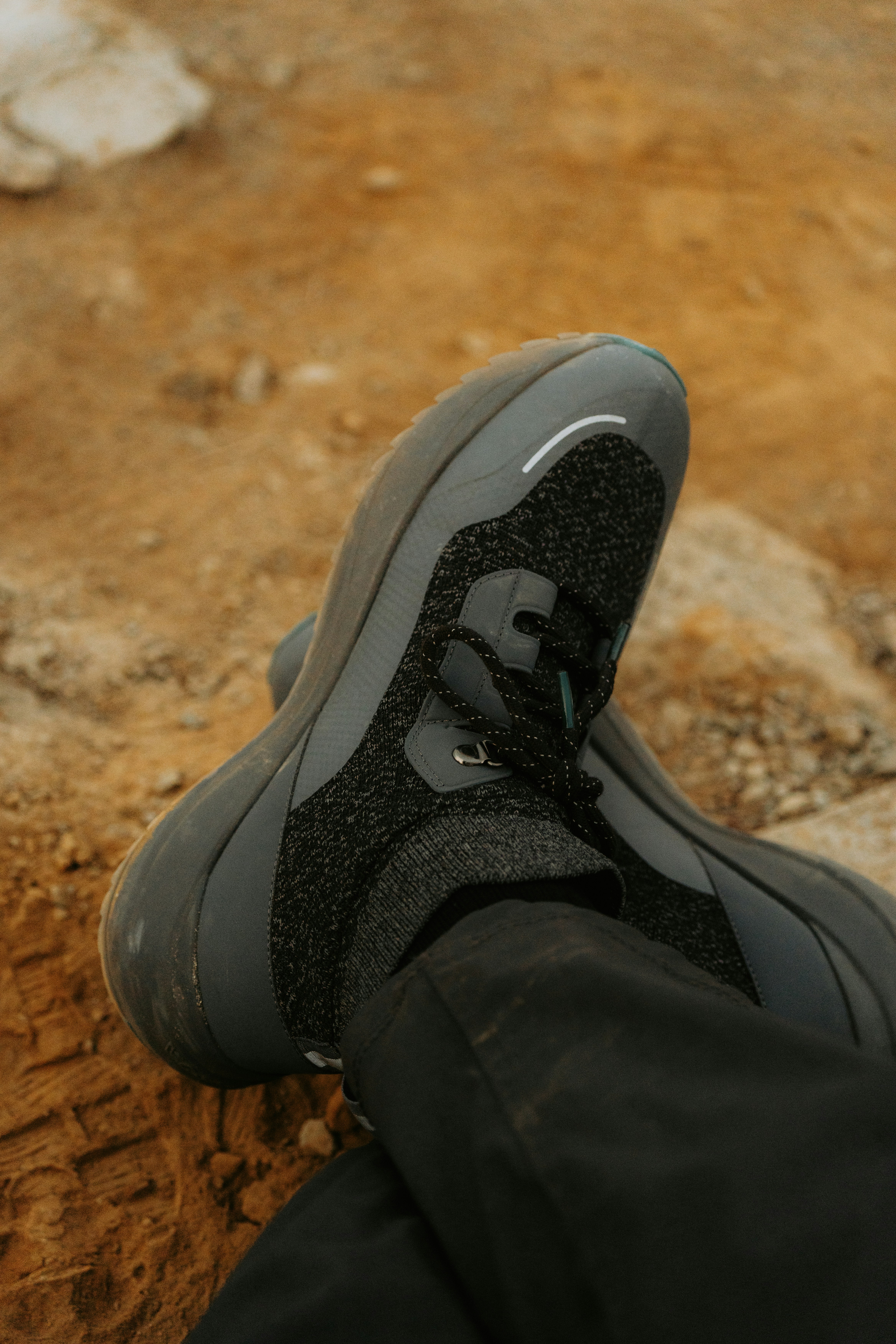 Paused on the Trail: A Rugged Sneaker Resting on Rusty Ground
