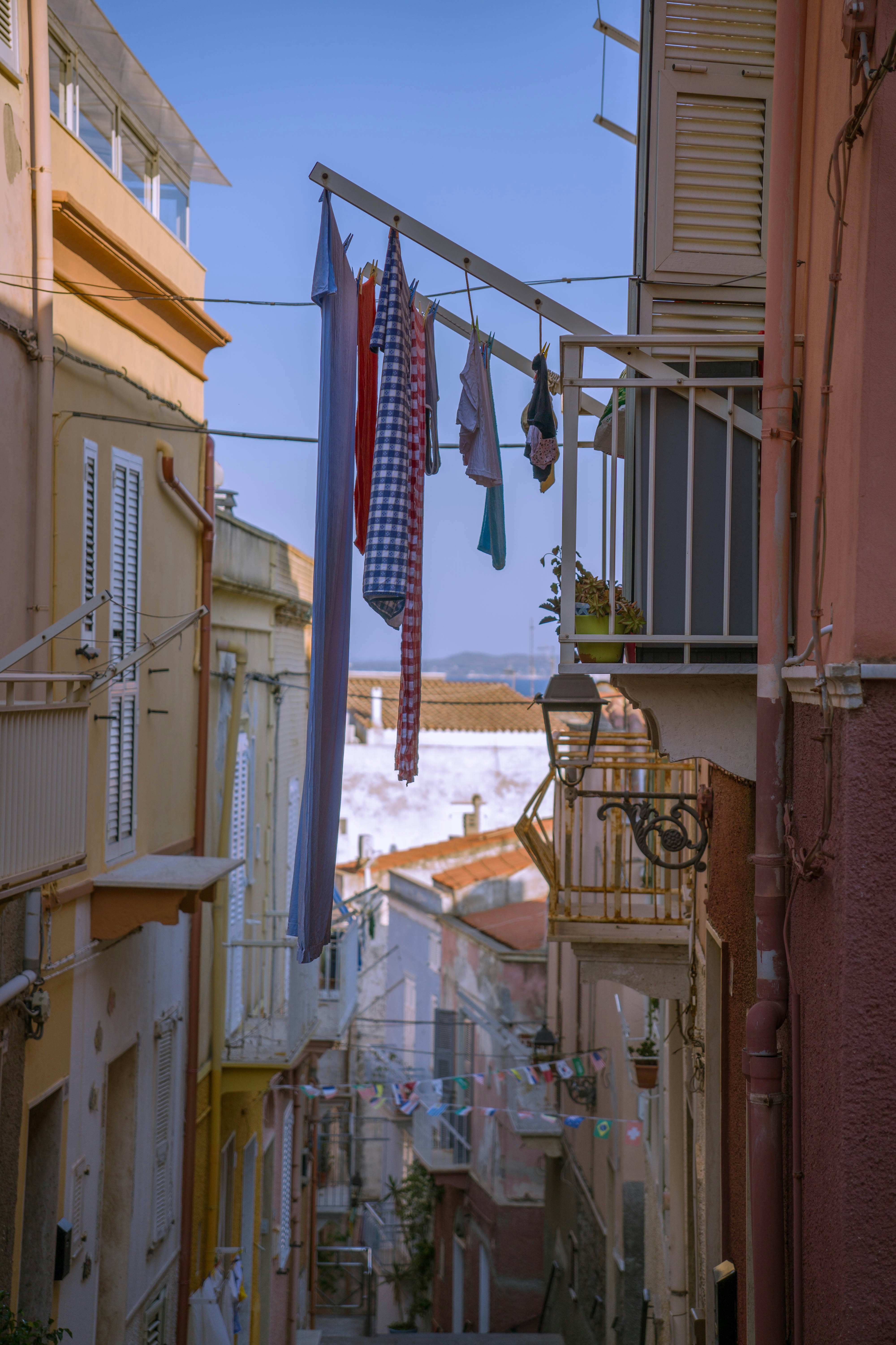 Sunlit Laundry Cascade Over a Narrow Mediterranean Alley