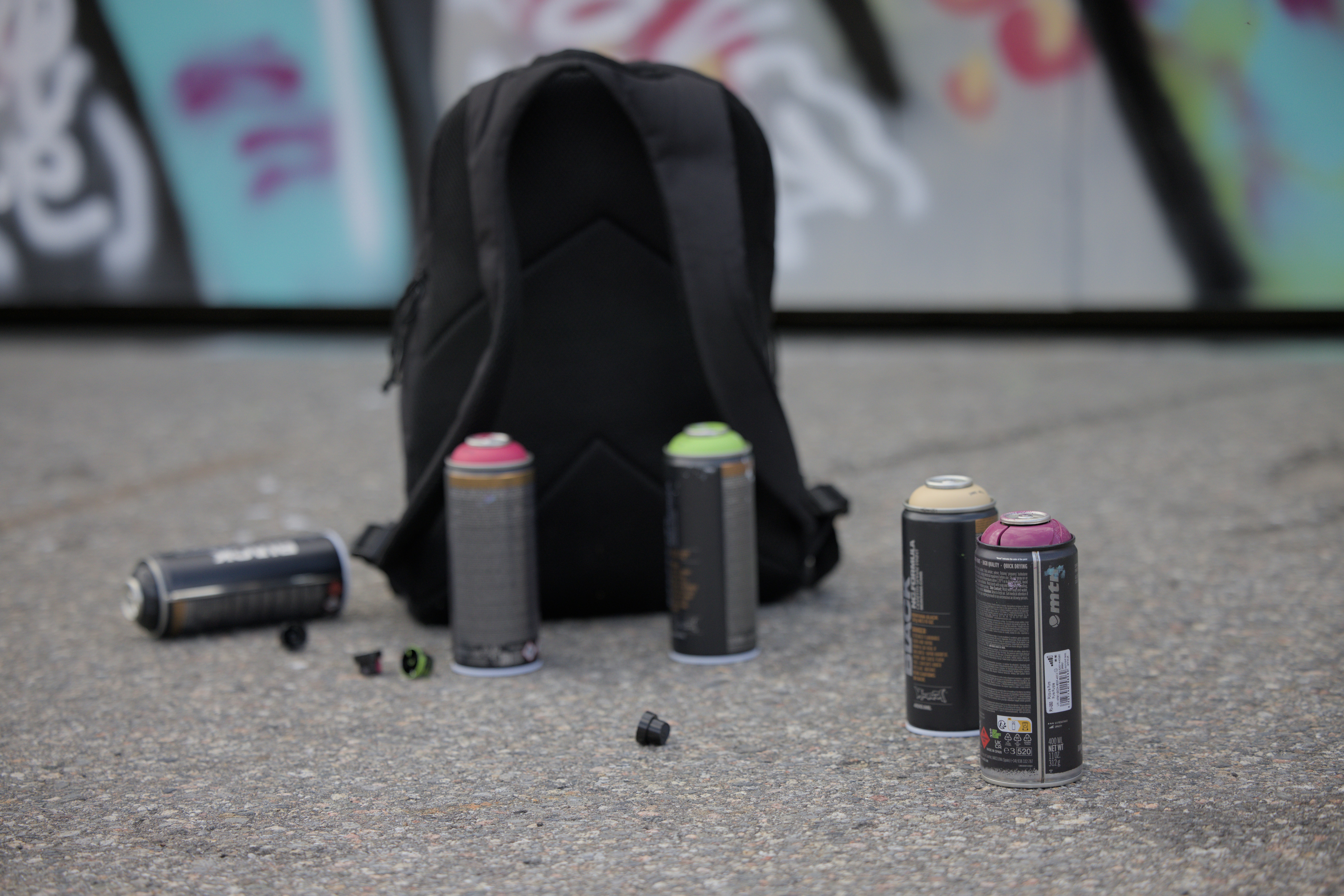 A backpack and several cans of soda on the ground photo – Free Street ...