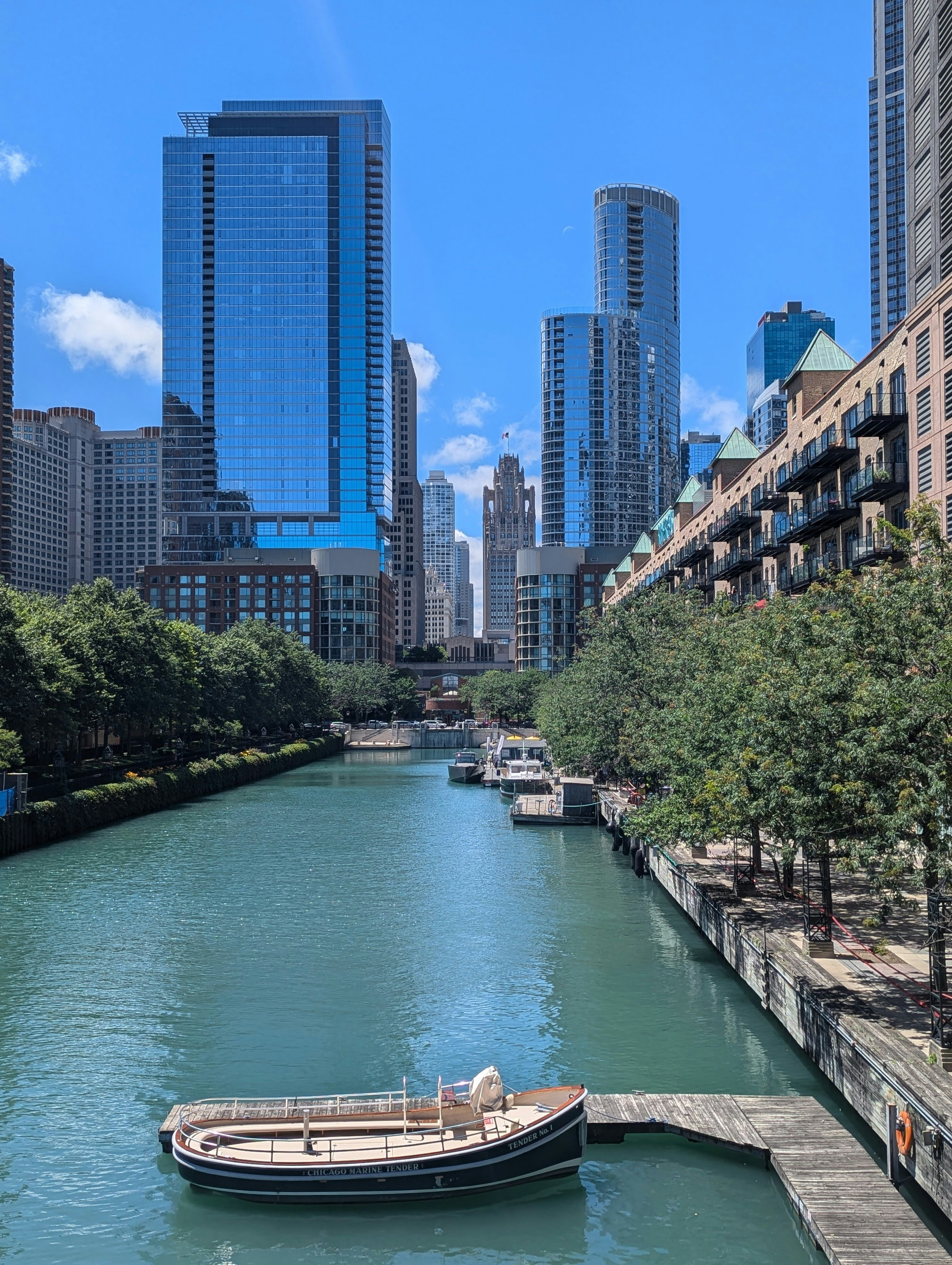 A boat floating down a river next to tall buildings photo – Free ...