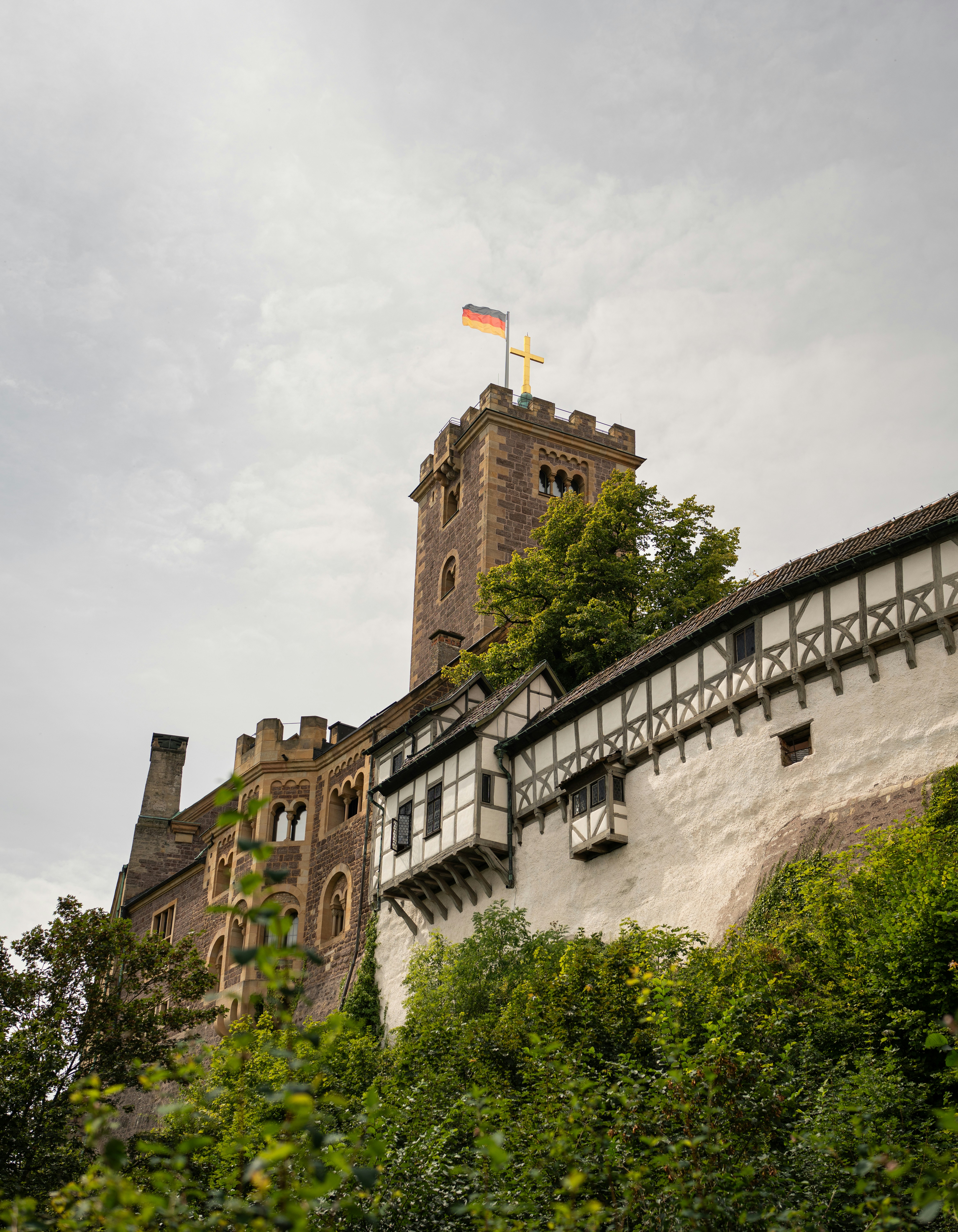 Turreted Fortress Above Timbered Walls, Flag and Cross Crown the Summit