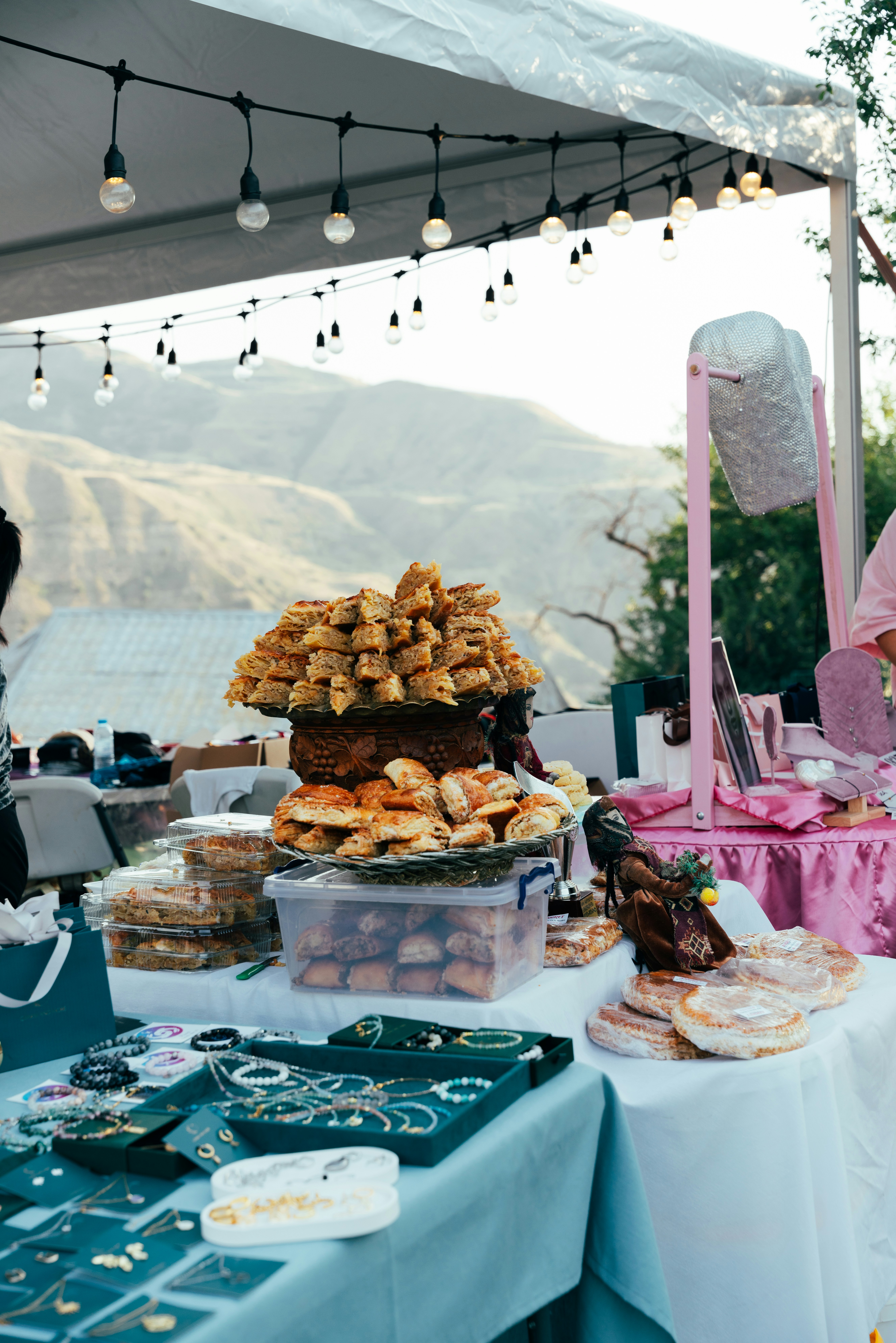 Market Sweets: Stacks of Pastries and a Pink Cash-Stand Under String Lights