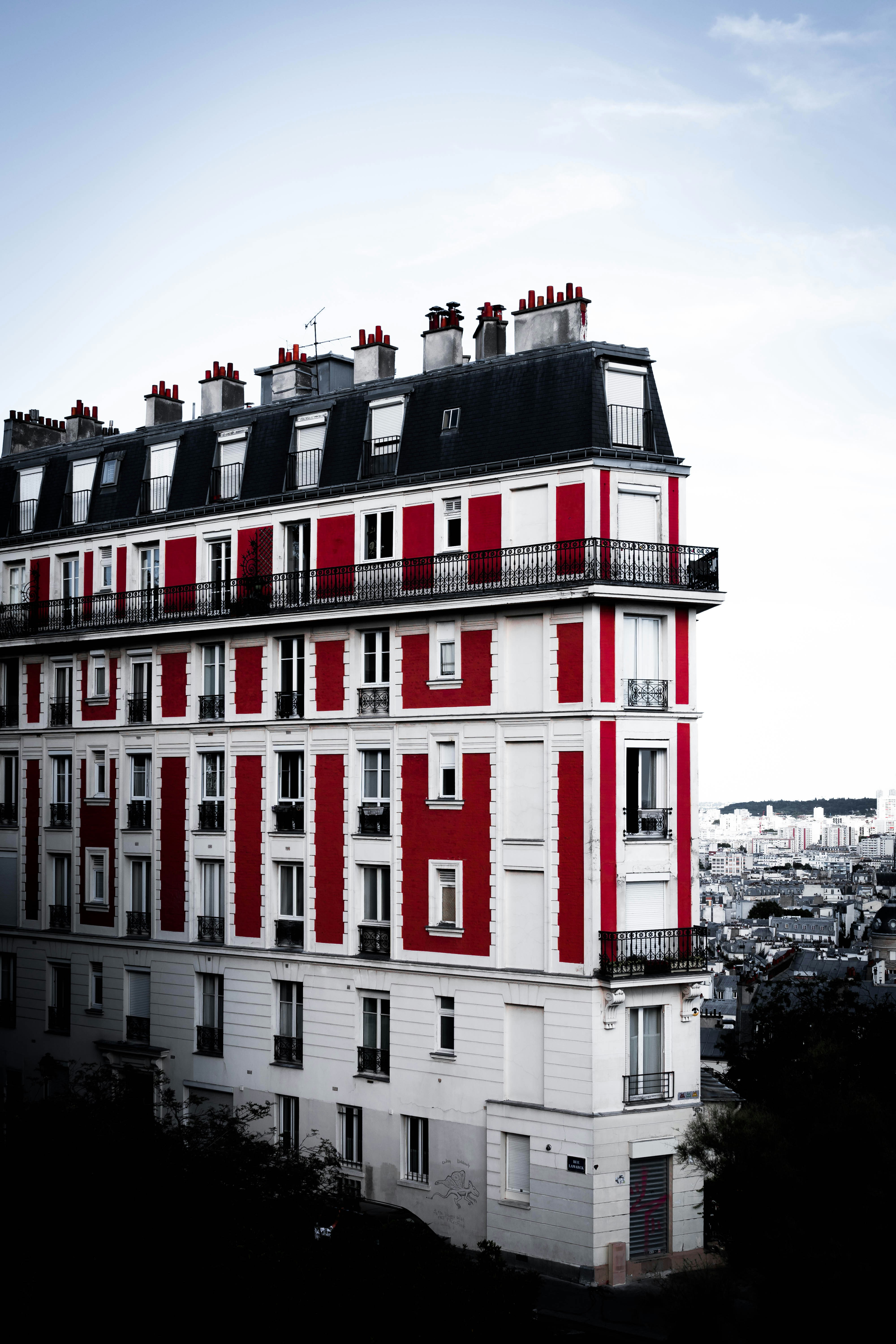 A red and white building with windows and balconiesMatt Pictures