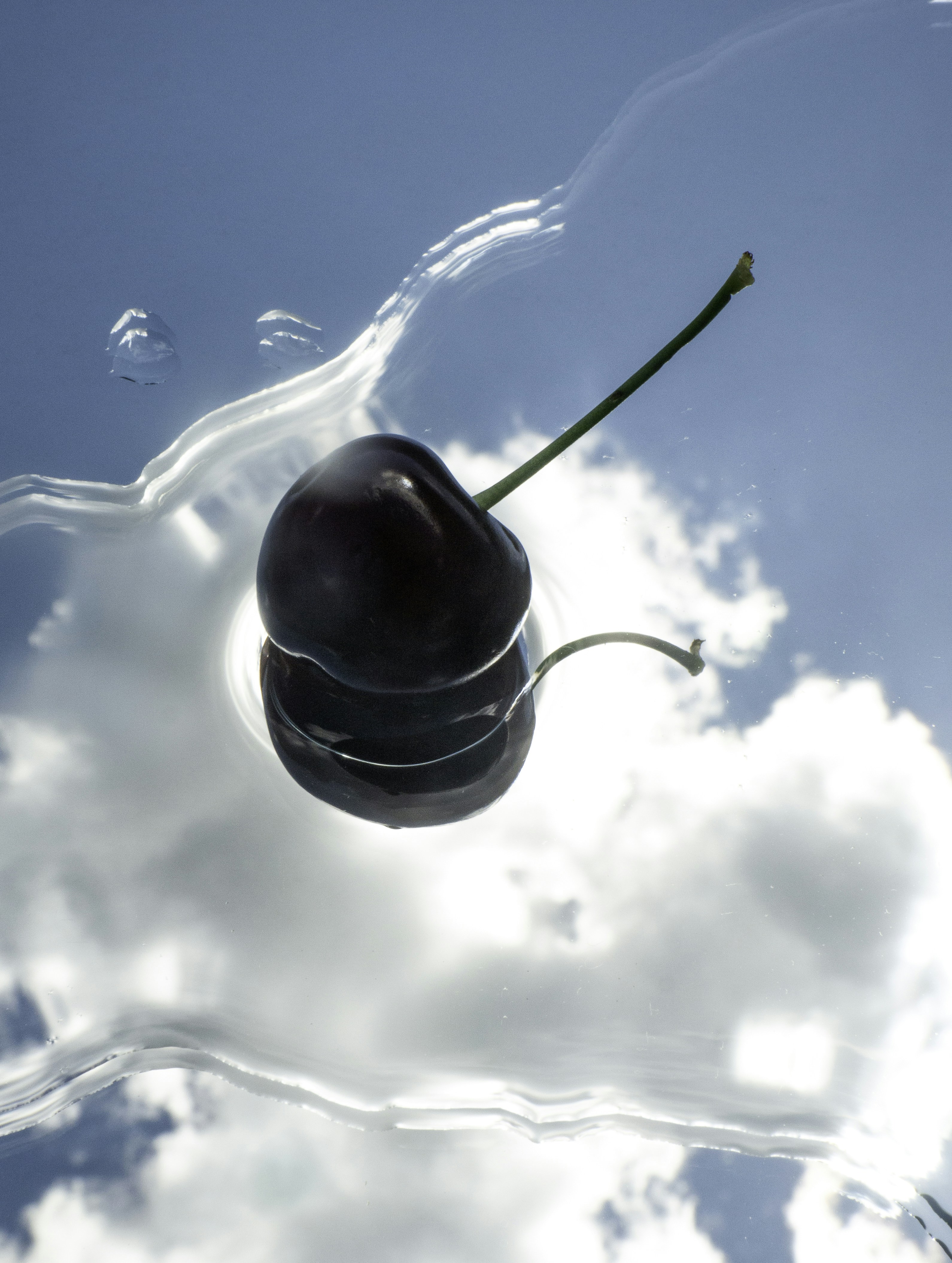A cherry floating in the water with a sky background photo – Free ...