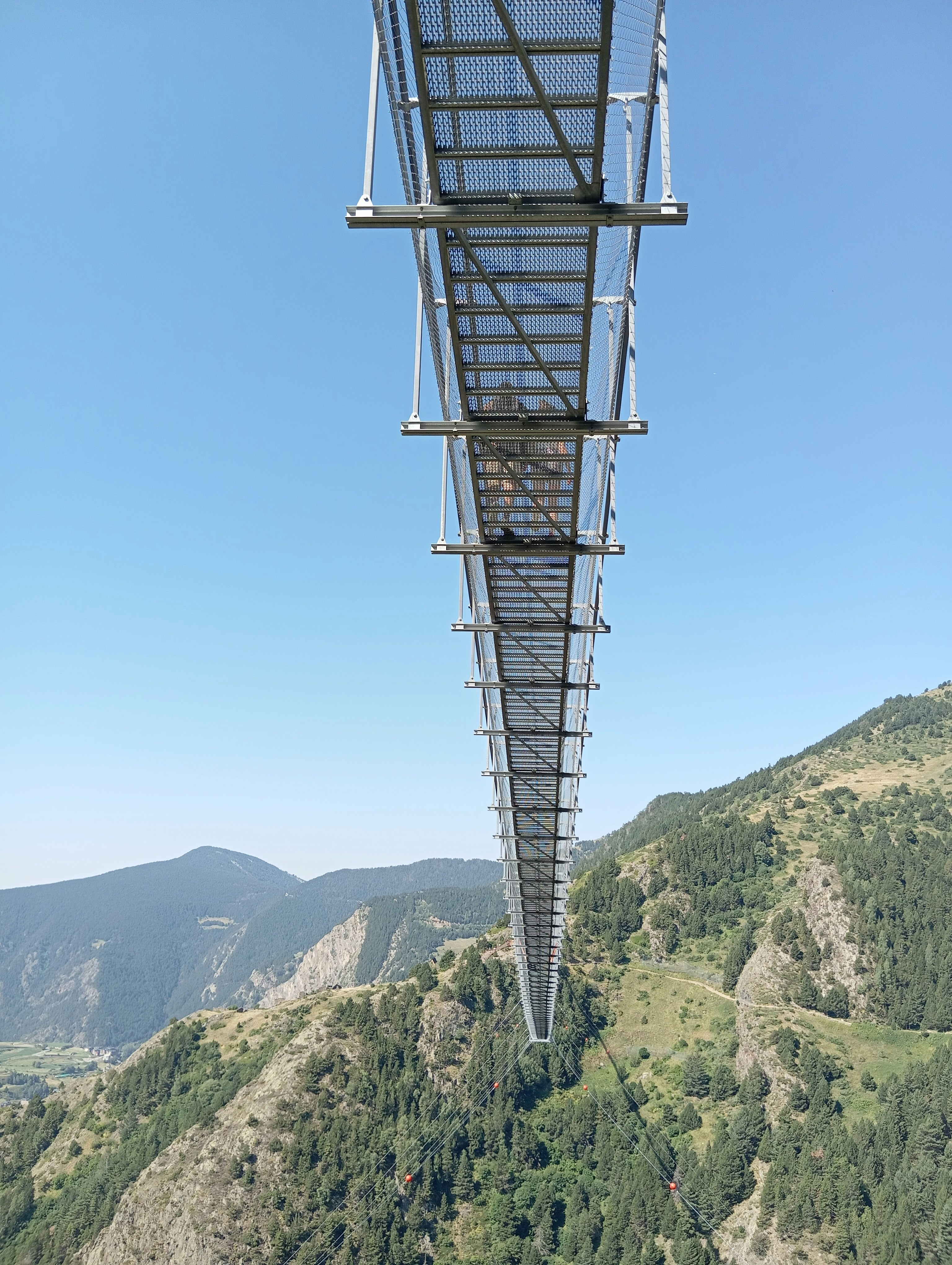 Une haute structure métallique posée au sommet d’une colline verdoyante ...