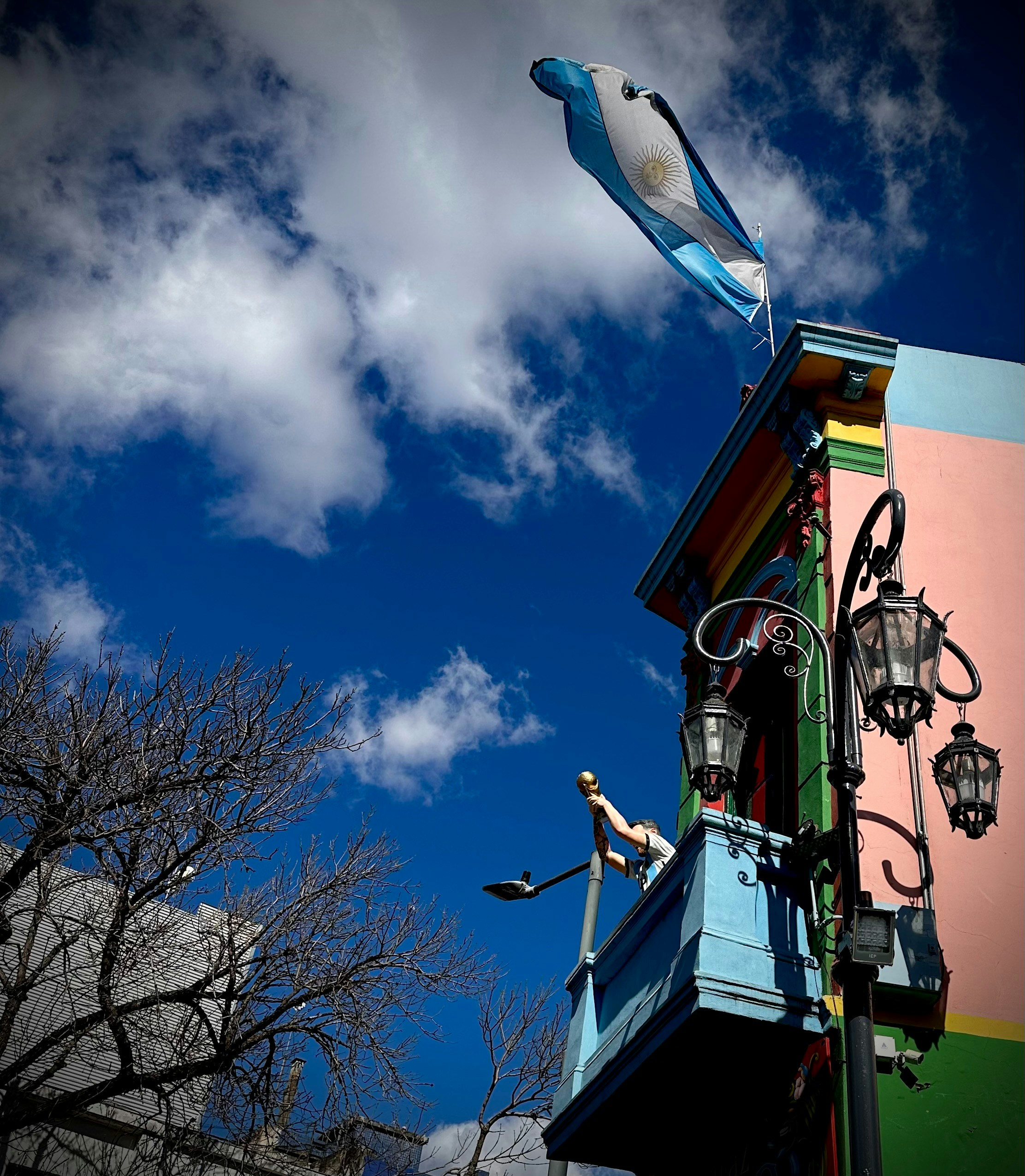 Vivid Balcony Ballet: Color-Block Facade Under an Argentine Flag