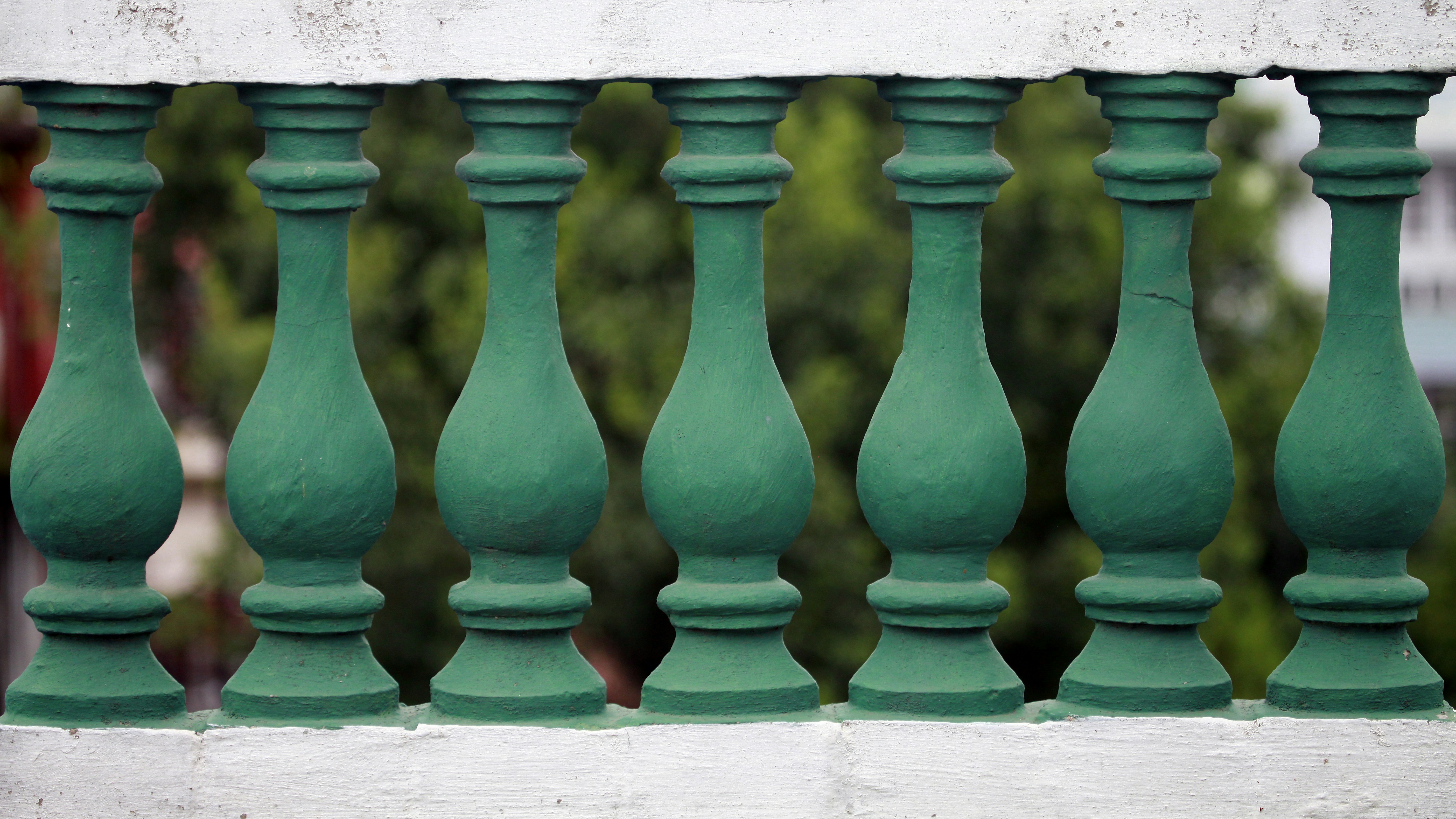 Rhythmic Teal Columns Against a Verdant Blur