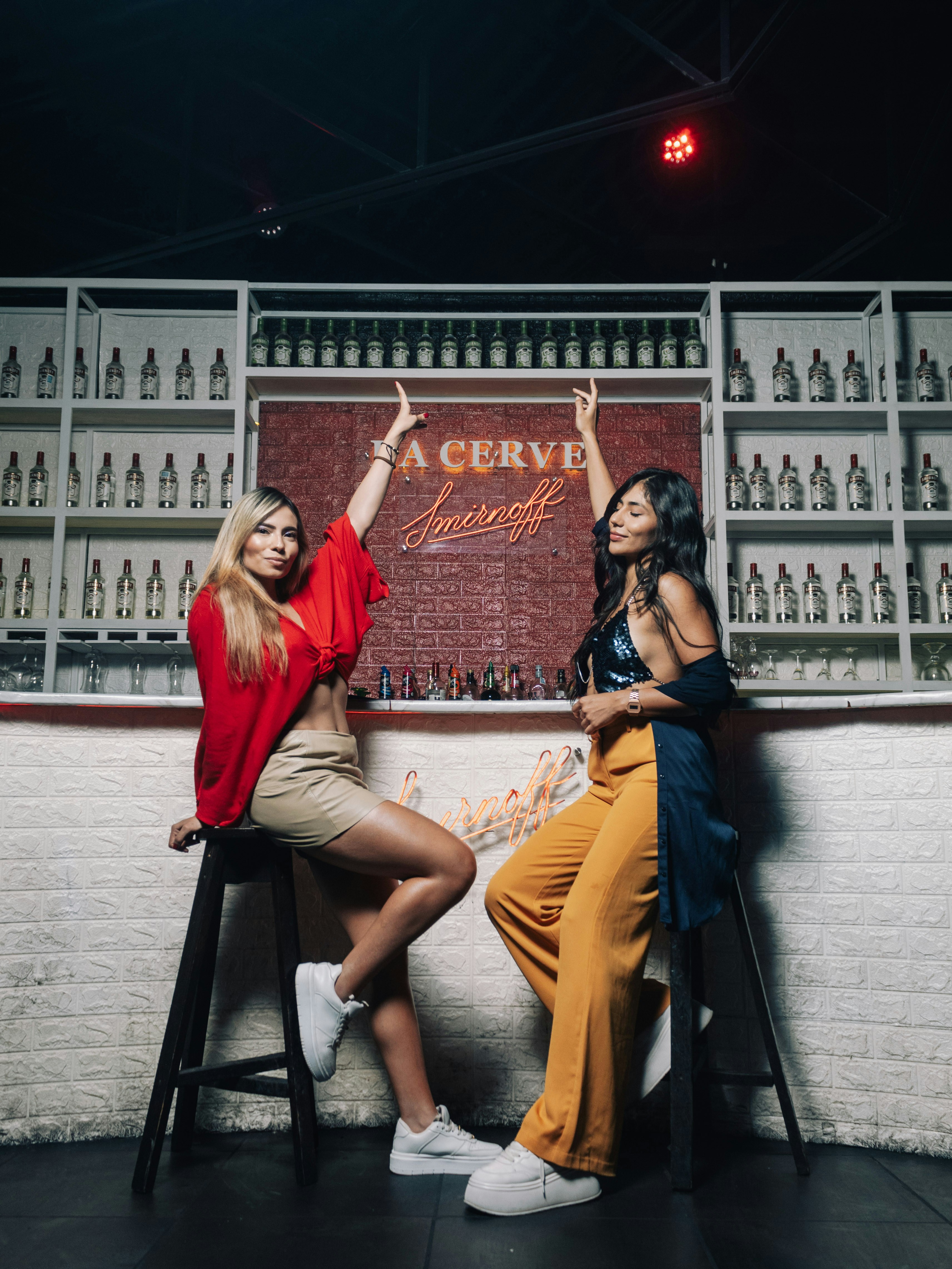 Two women sitting at a bar posing for a picture photo – Free Woman ...