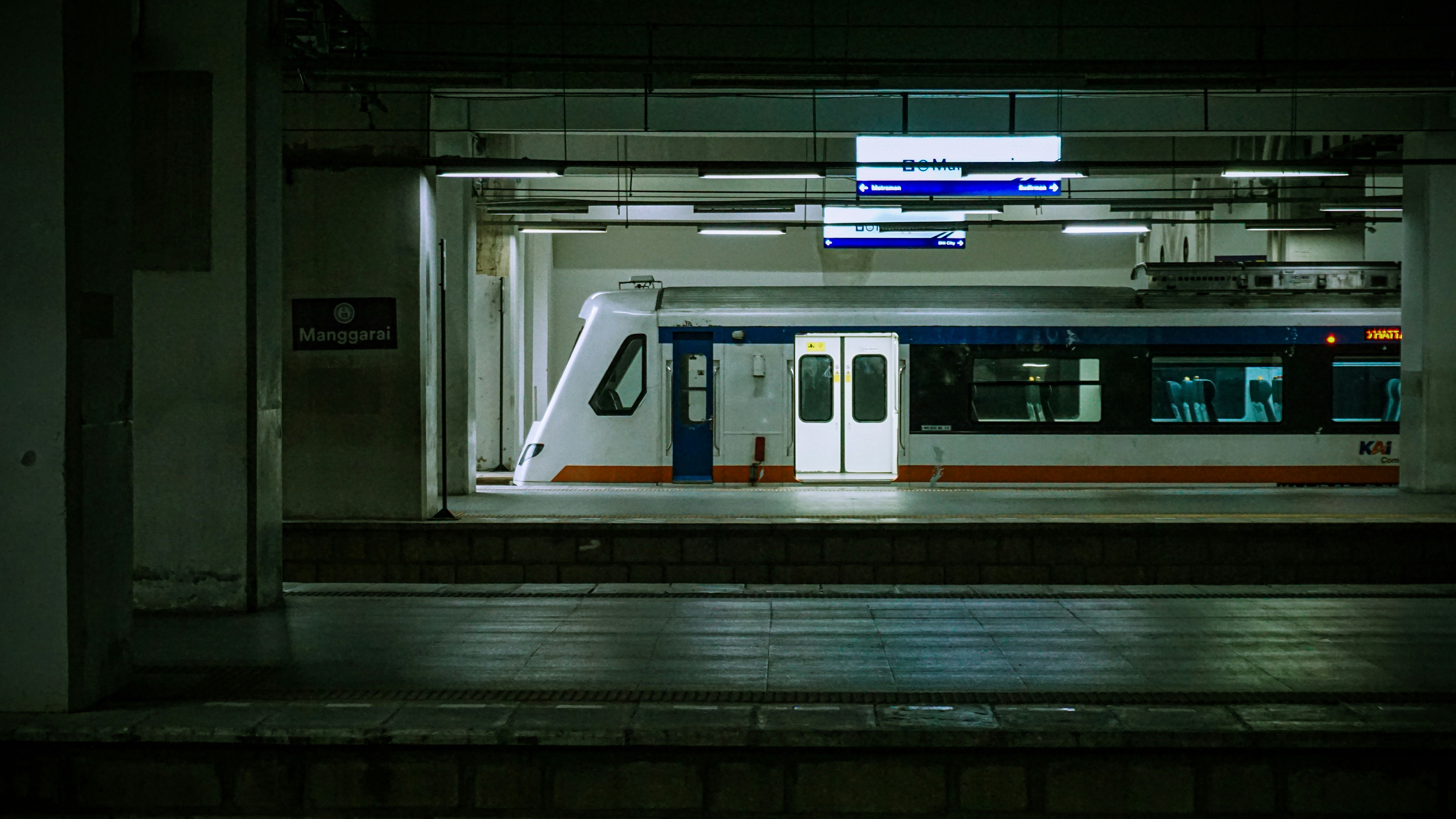 A subway station with a train in the background photo – Free Human ...