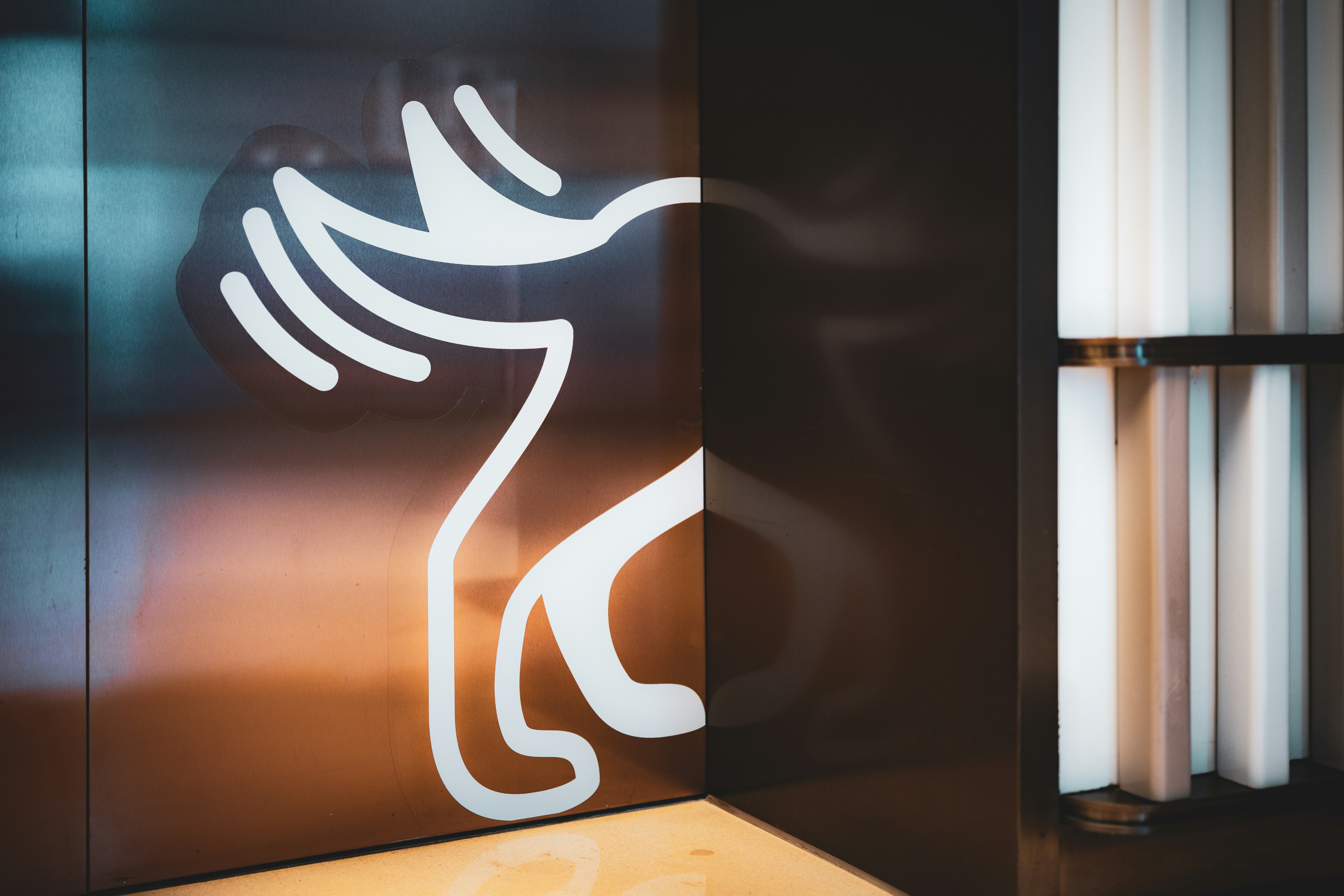 Corner Glow: Line-Art Hand Logo on Industrial Metal