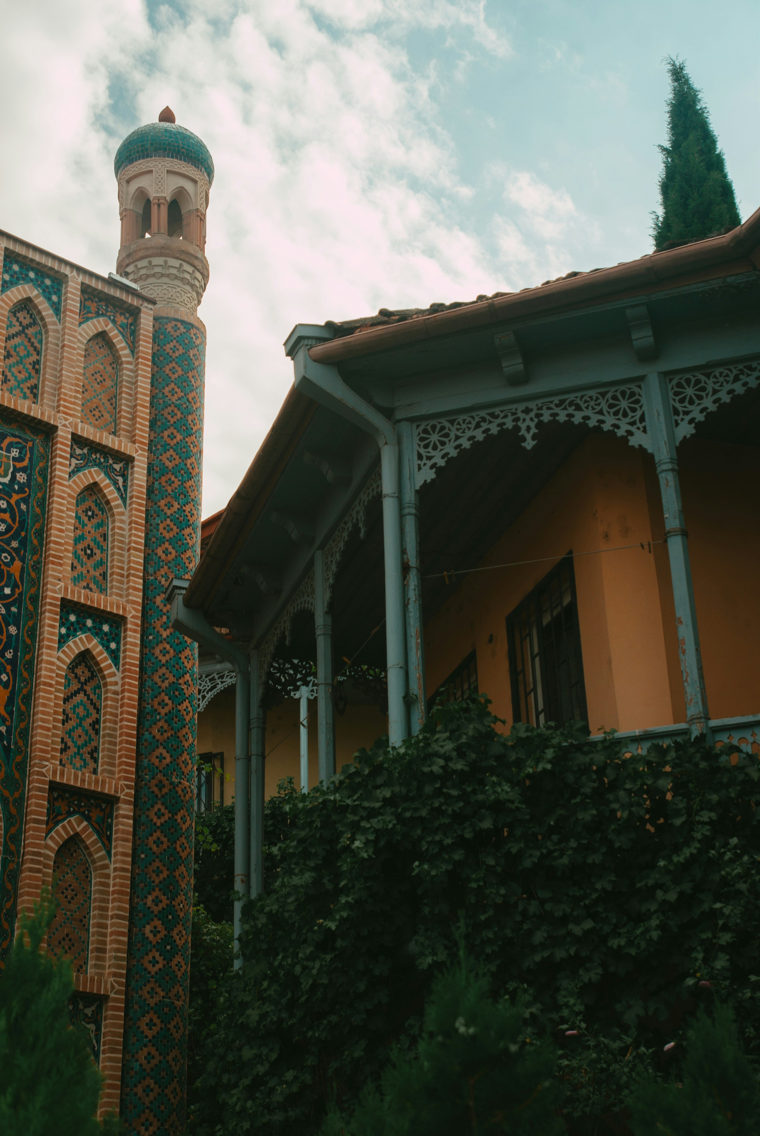 Architectural Echoes: A Turreted Mosaic Between Verandah and Ivy