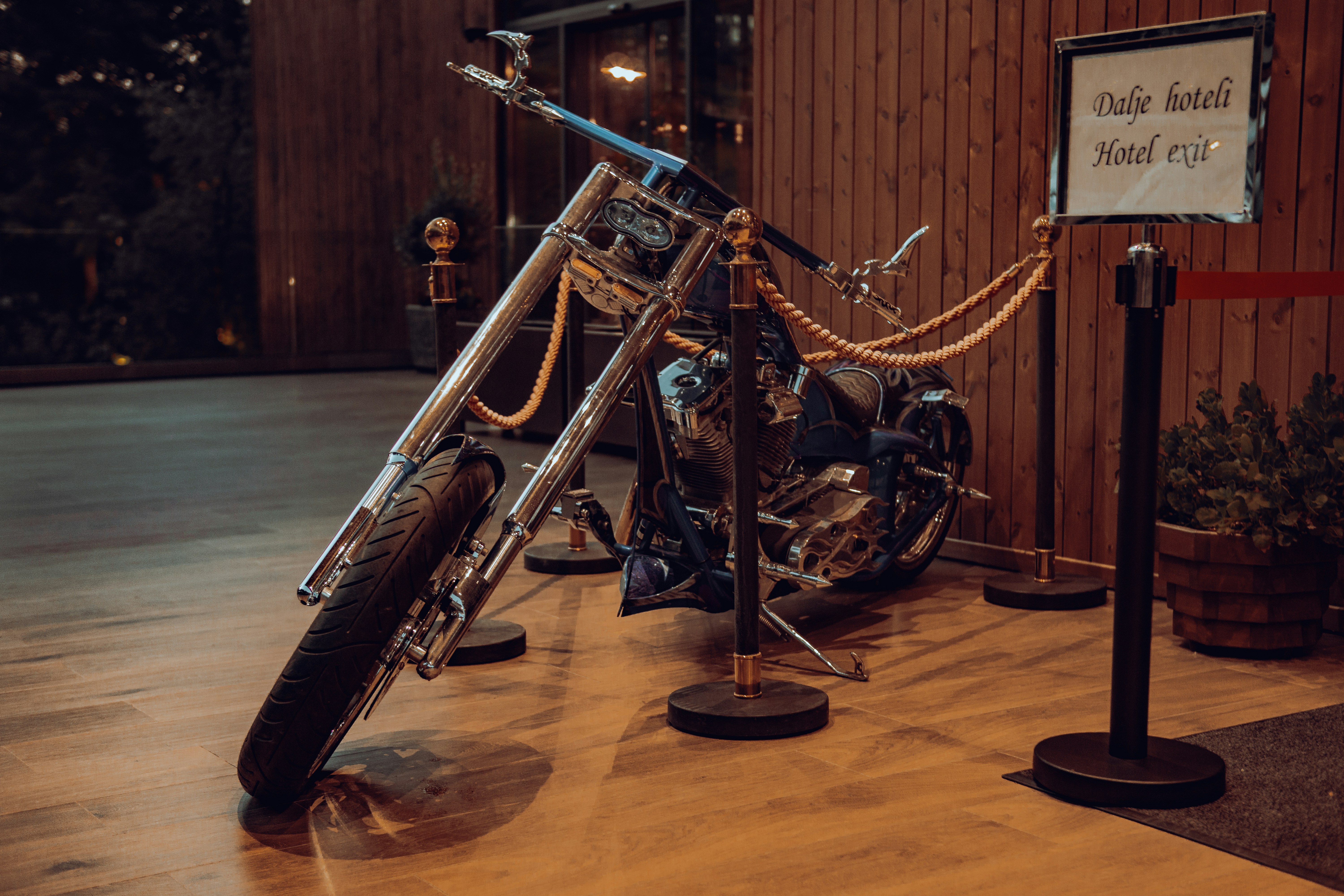 A motorcycle parked in a room with a roped off area photo – Free Wood ...