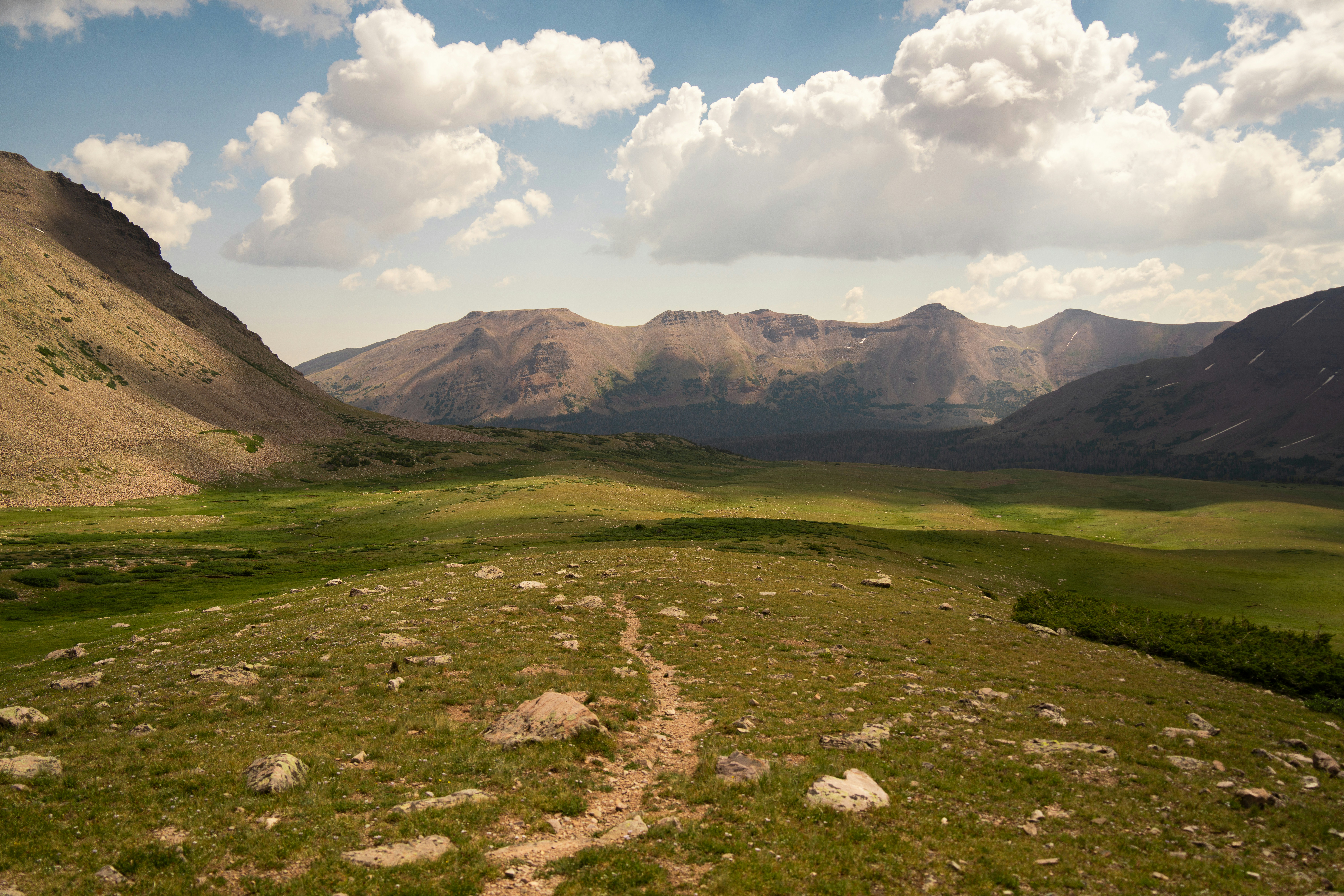 A wide open field with mountains in the background photo – Free Nature ...