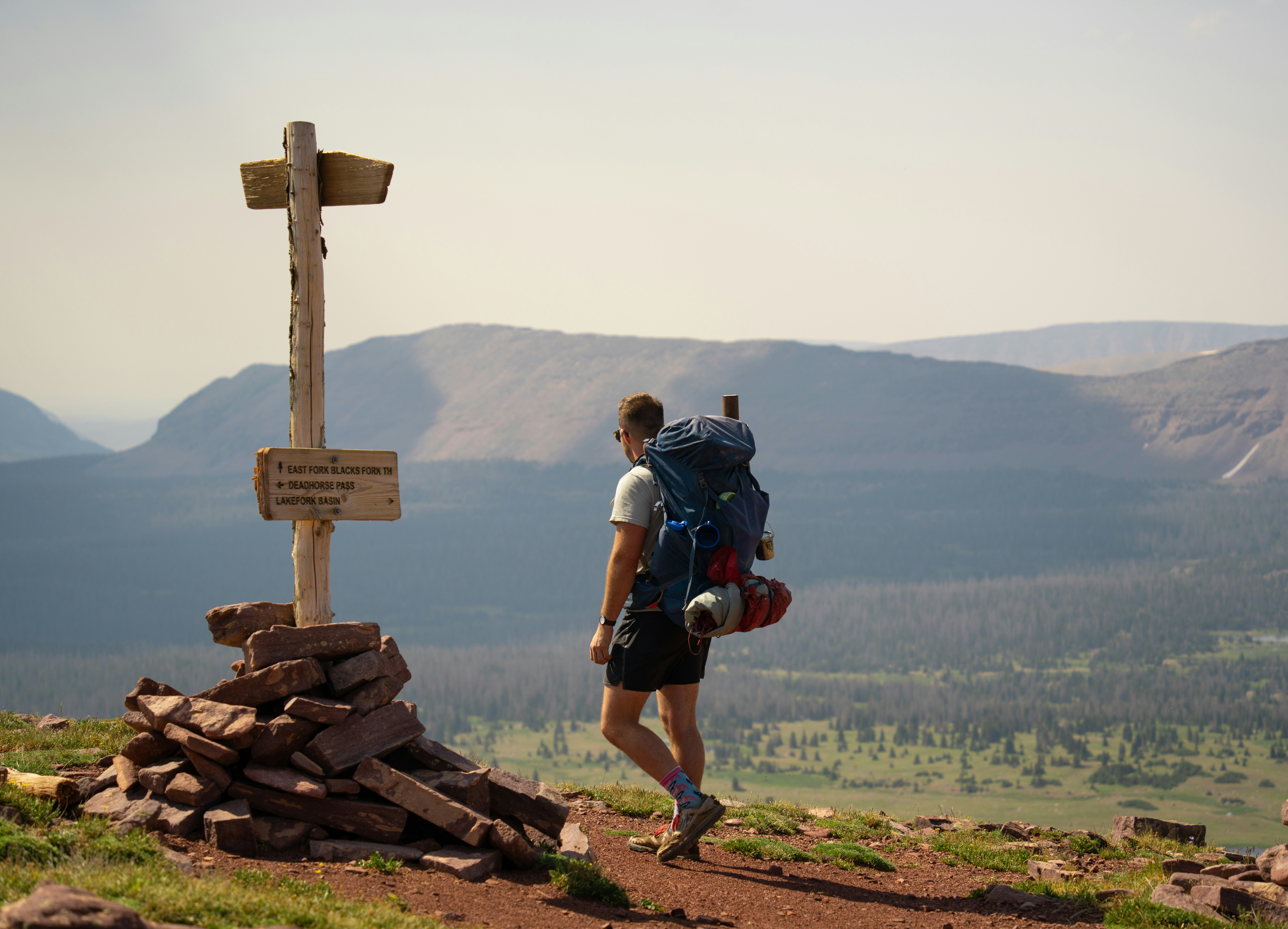 Ridge Pause: Hiker at the Signpost Overlooking the Valley