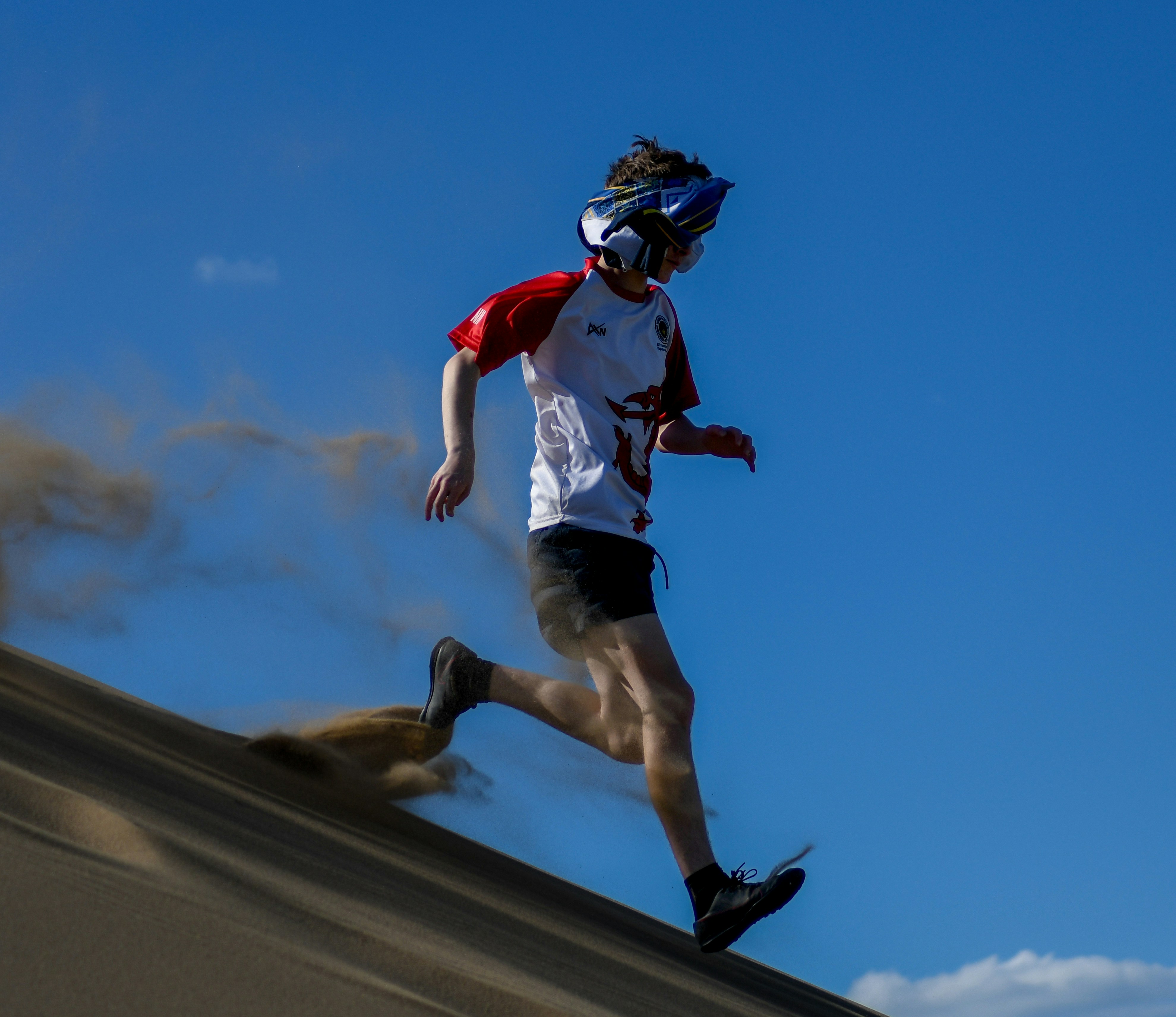 A man running down a hill with a helmet on photo – Free Merthyr mawr ...