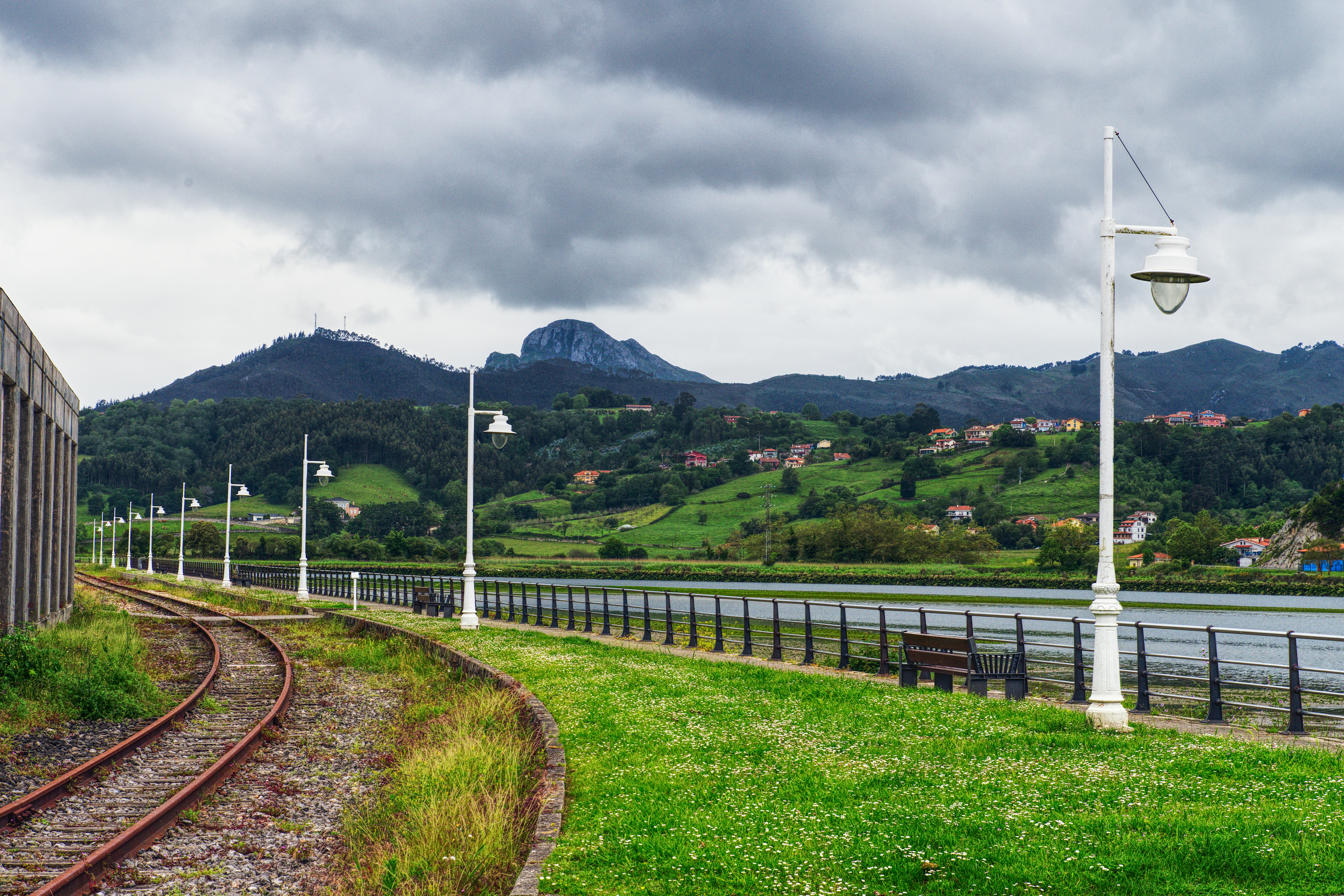 Riverside Curve: Railway, Lamps, and Distant Hills