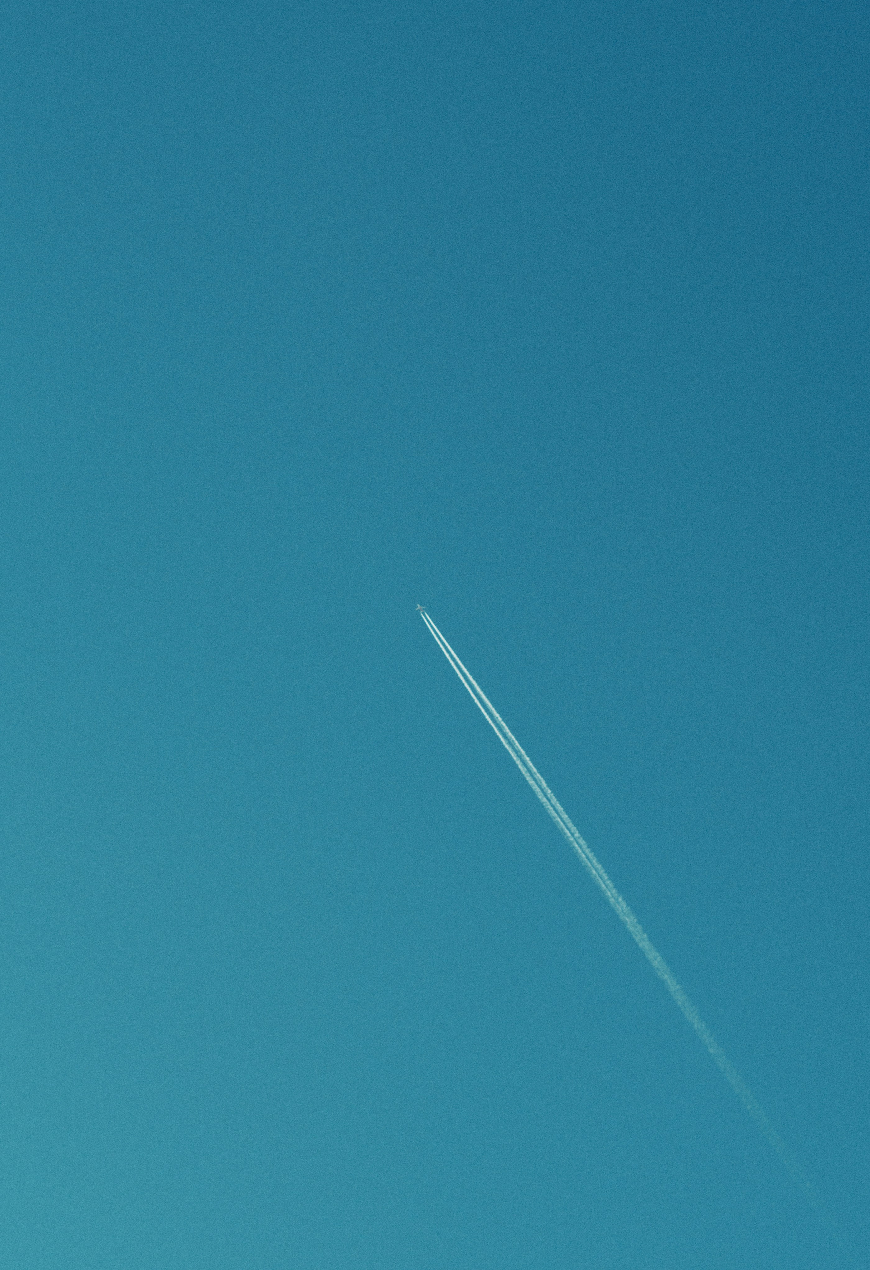 Um jato voando através de um céu azul com um rastro foto – Imagem ...