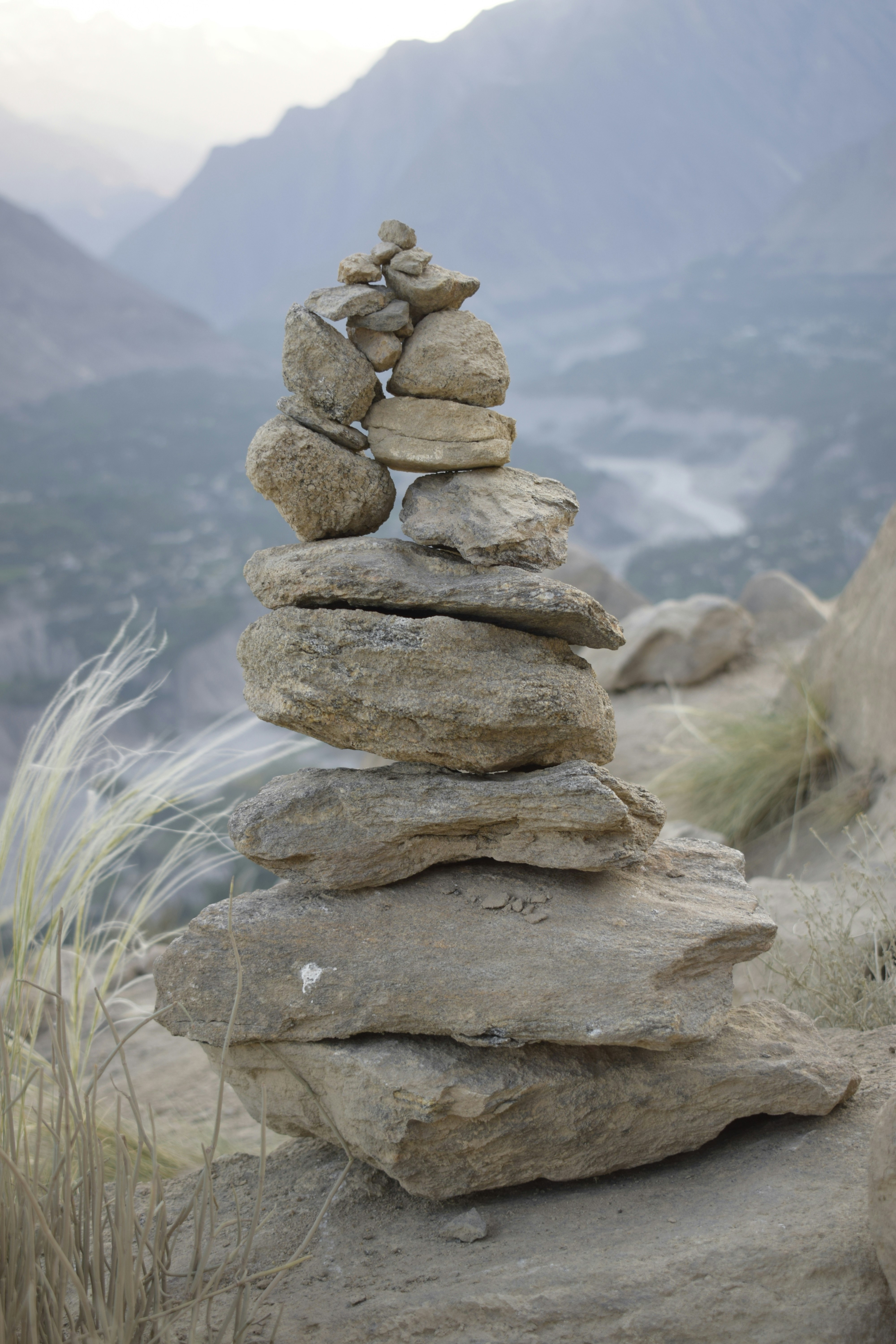 Cairn at the Edge of Dawn over Alpine Valleys