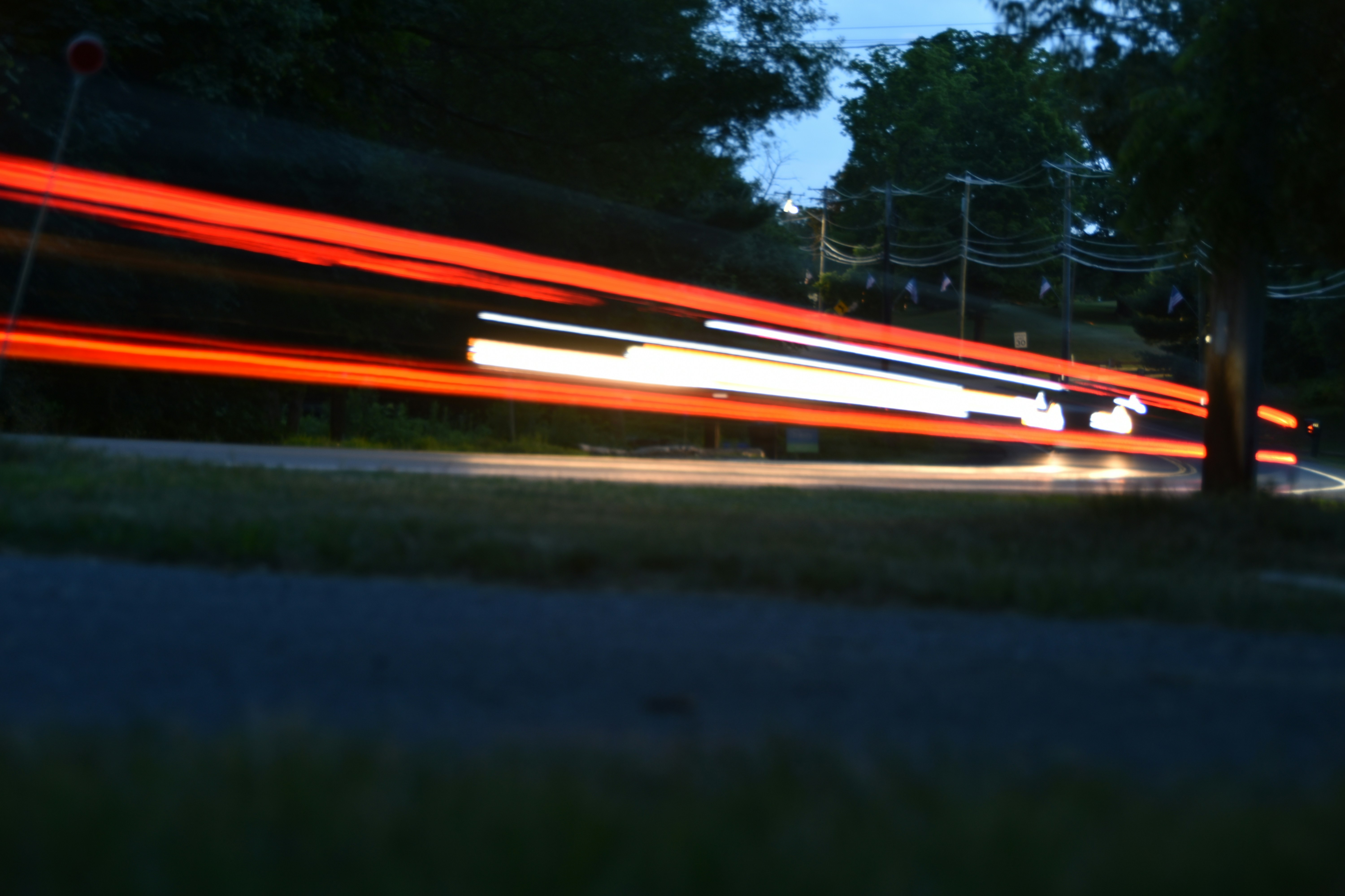 Red Streaks Across a Quiet Road at Dusk