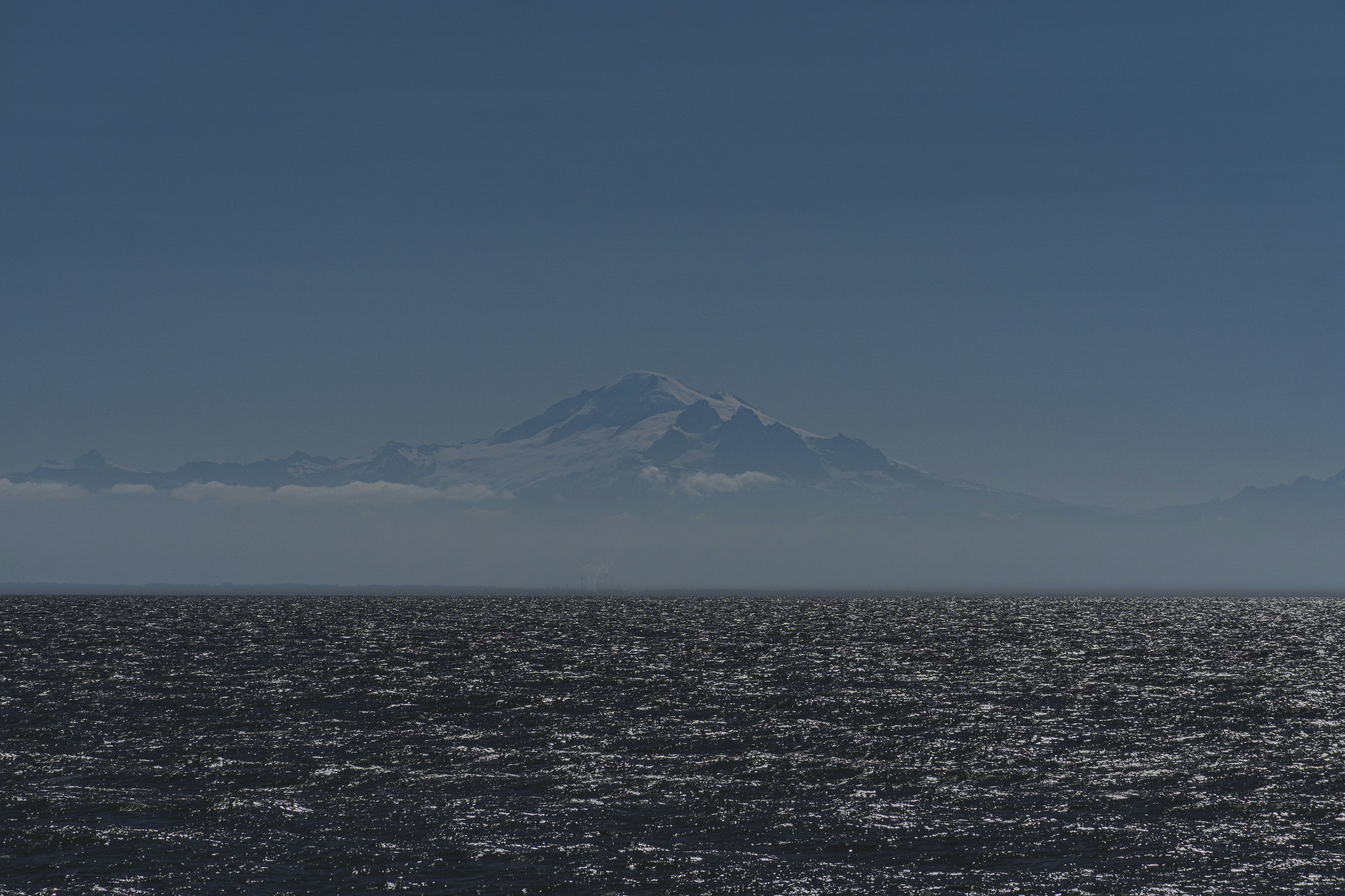 Snow-Capped Sentinel Over a Quiet Sea