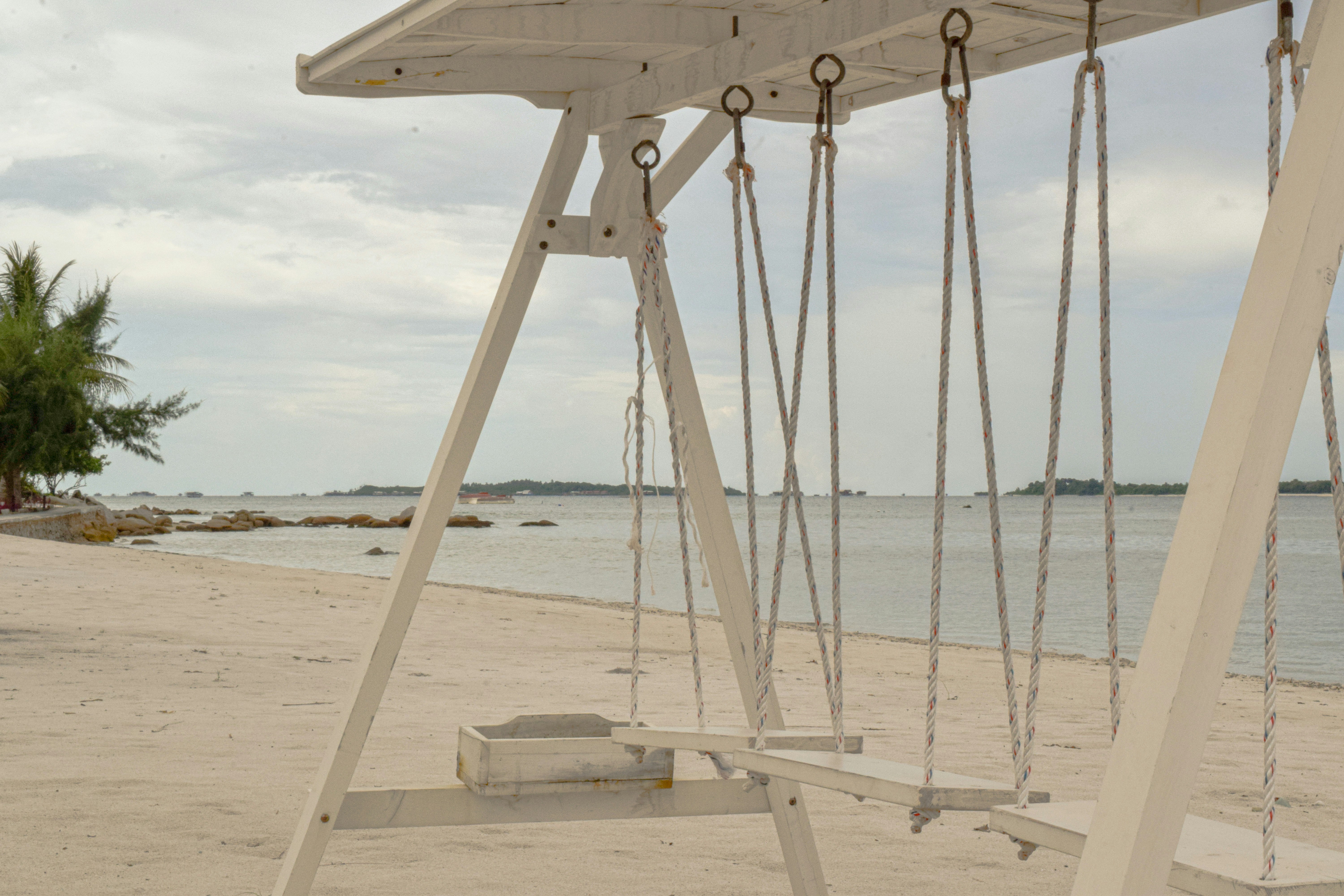Rope and Rays: A Quiet Beach Swing Framed by Sea and Sky
