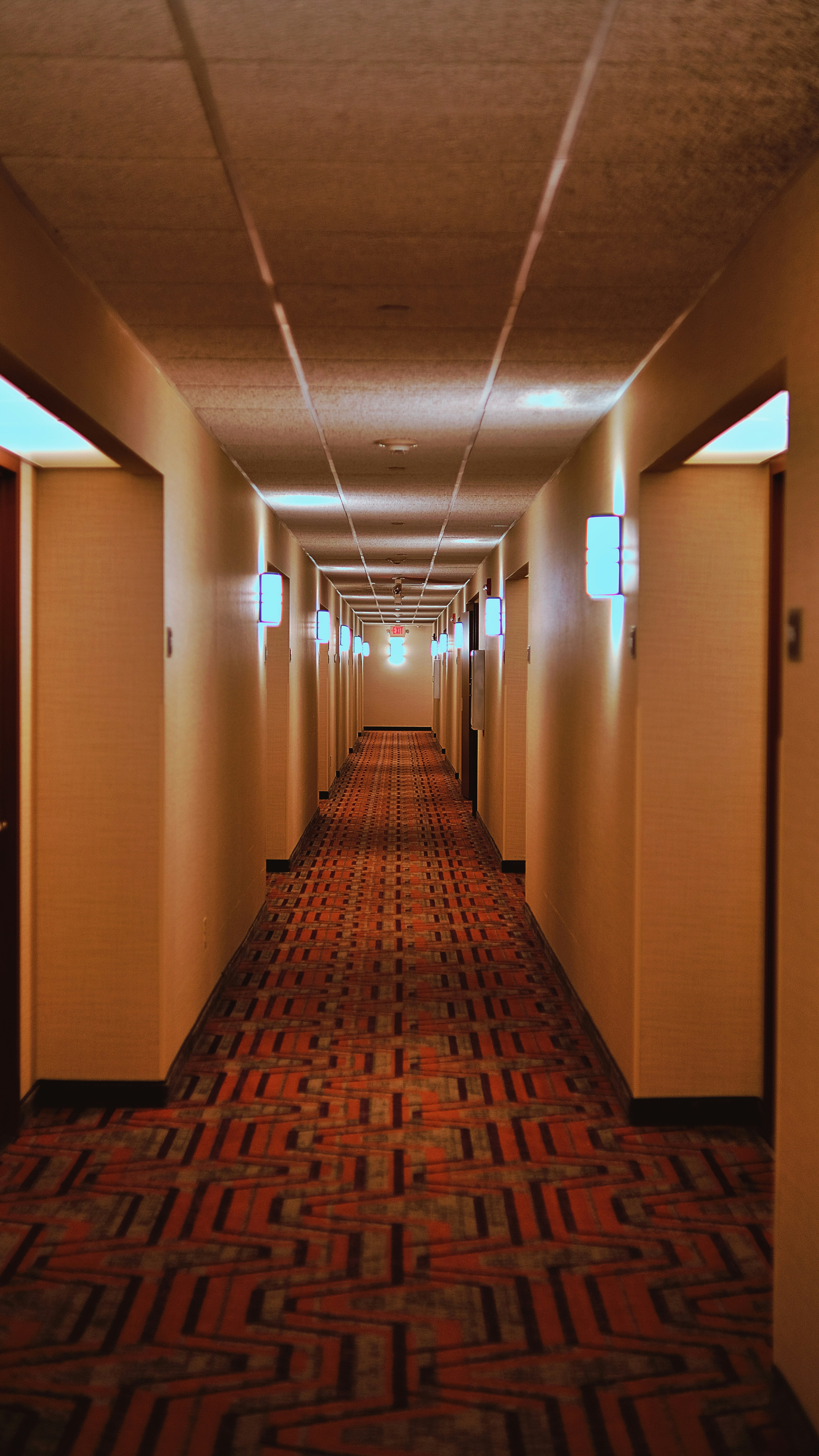 A long hallway with a red carpet and white walls photo – Free Drury inn ...