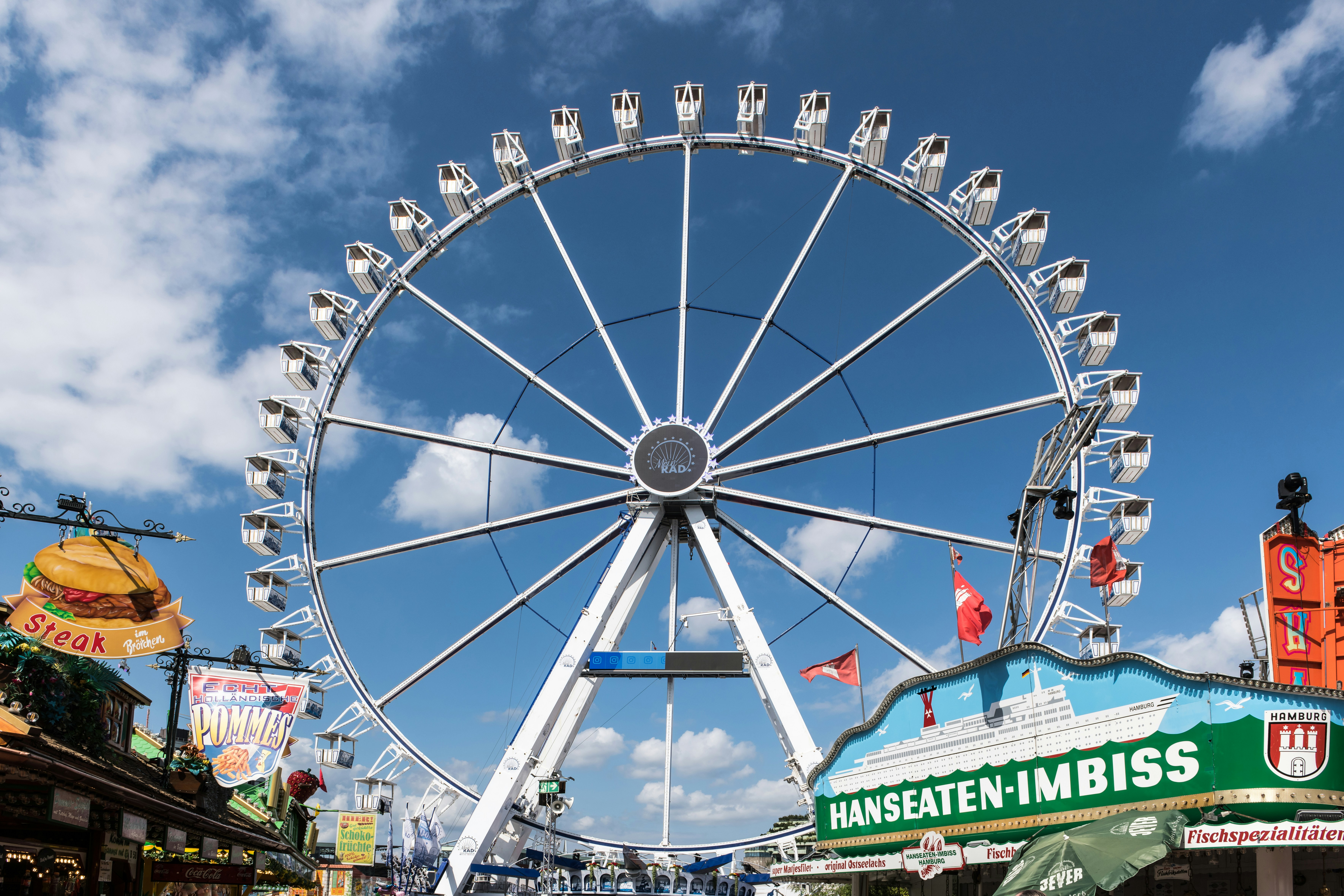 Wheel Over the Fair: A Sunlit German Market Framed by Signage