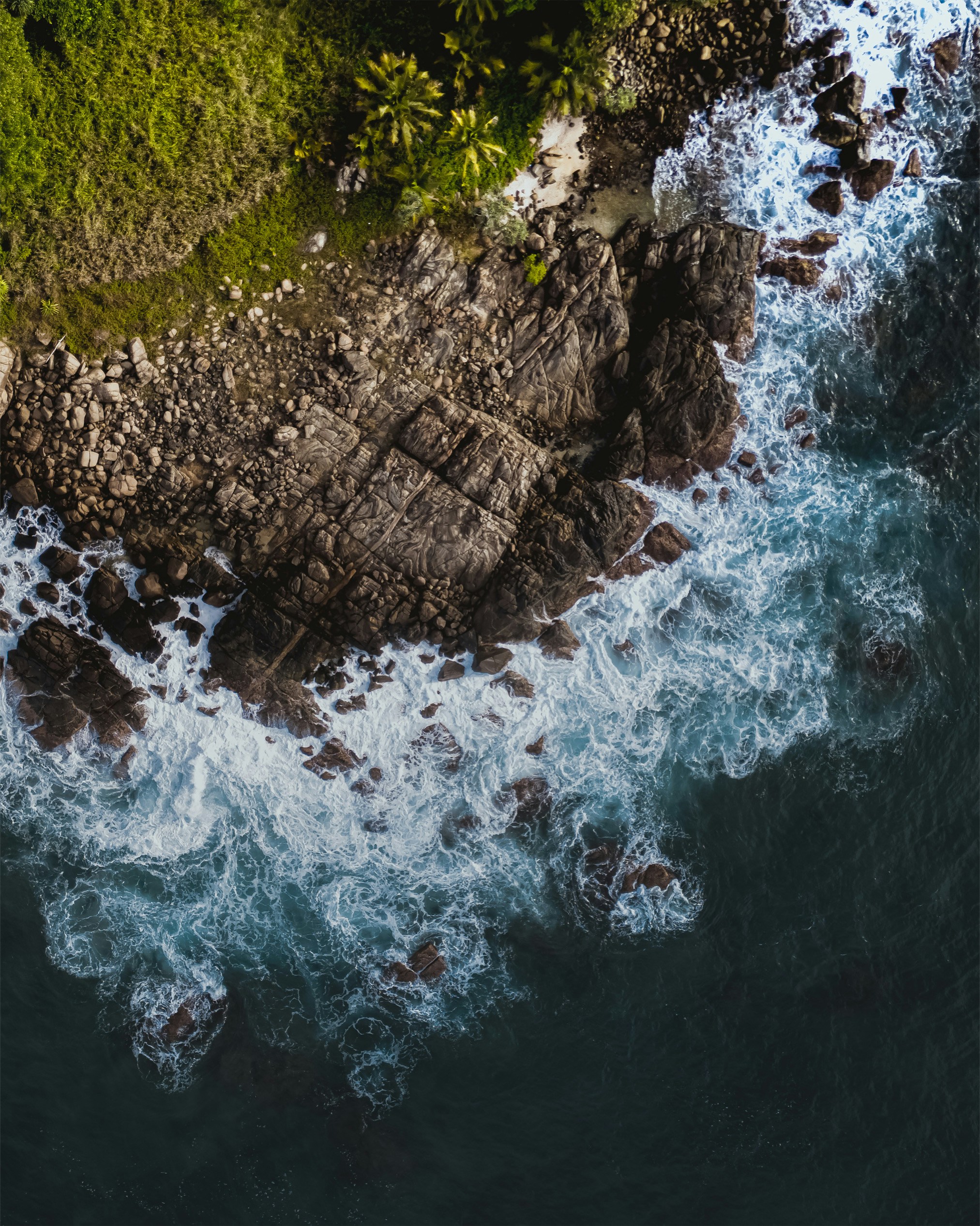 A bird's eye view of the ocean and a rock outcropping photo – Free ...