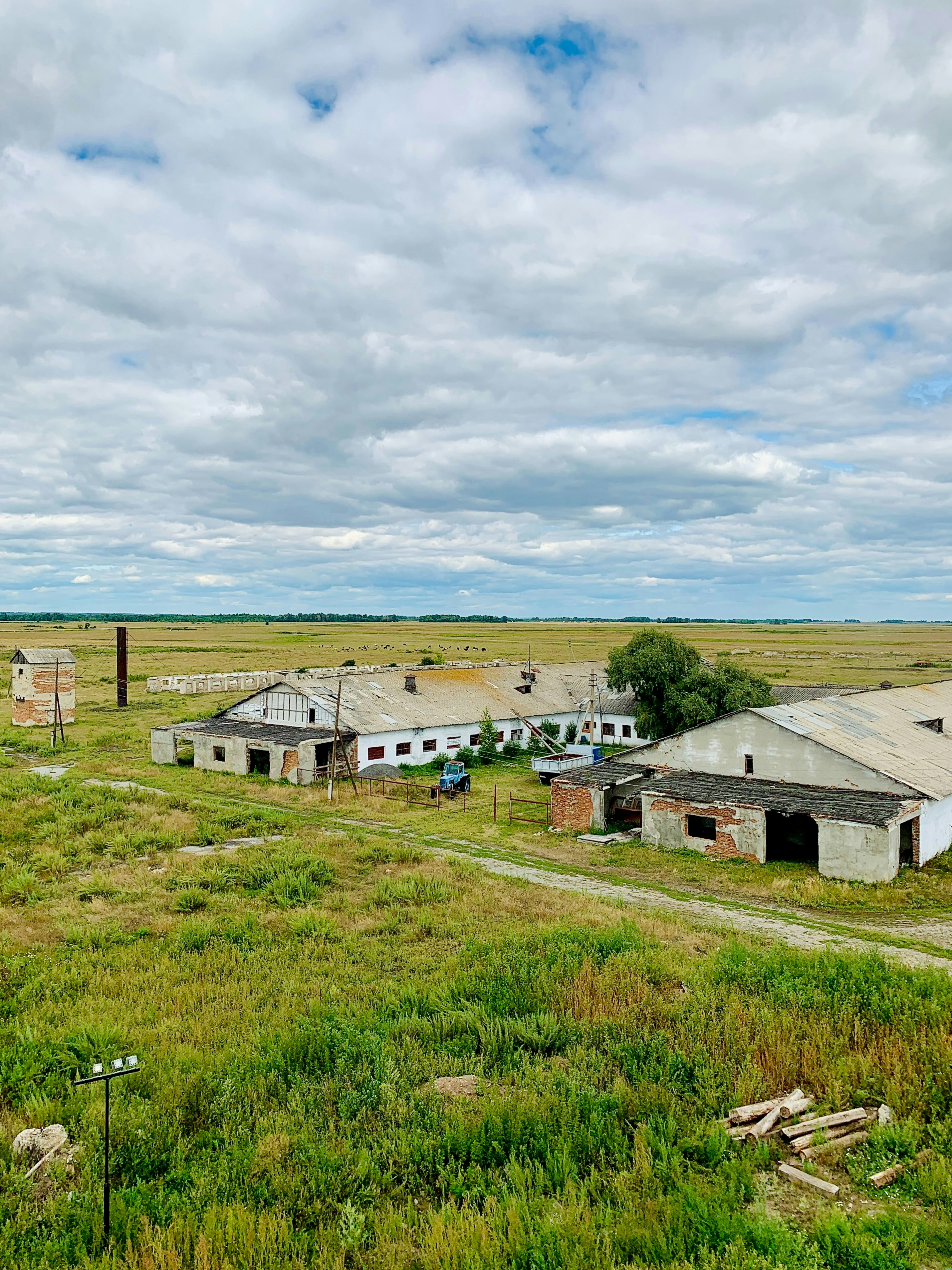 Weathered Farmstead Beneath a Cloud-Swept Prairie Sky