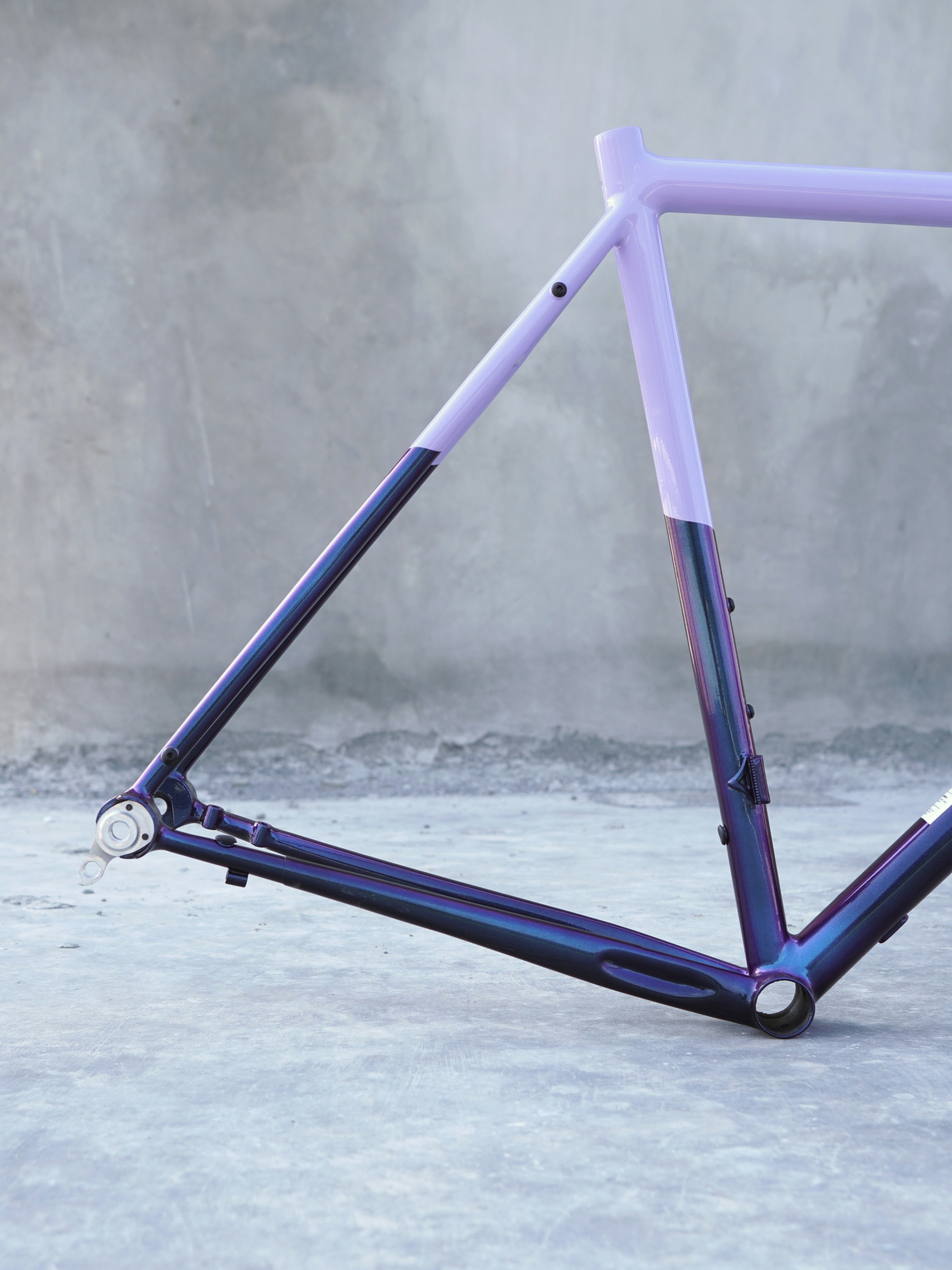 A purple bicycle frame sitting on the ground photo – Free Triangle ...
