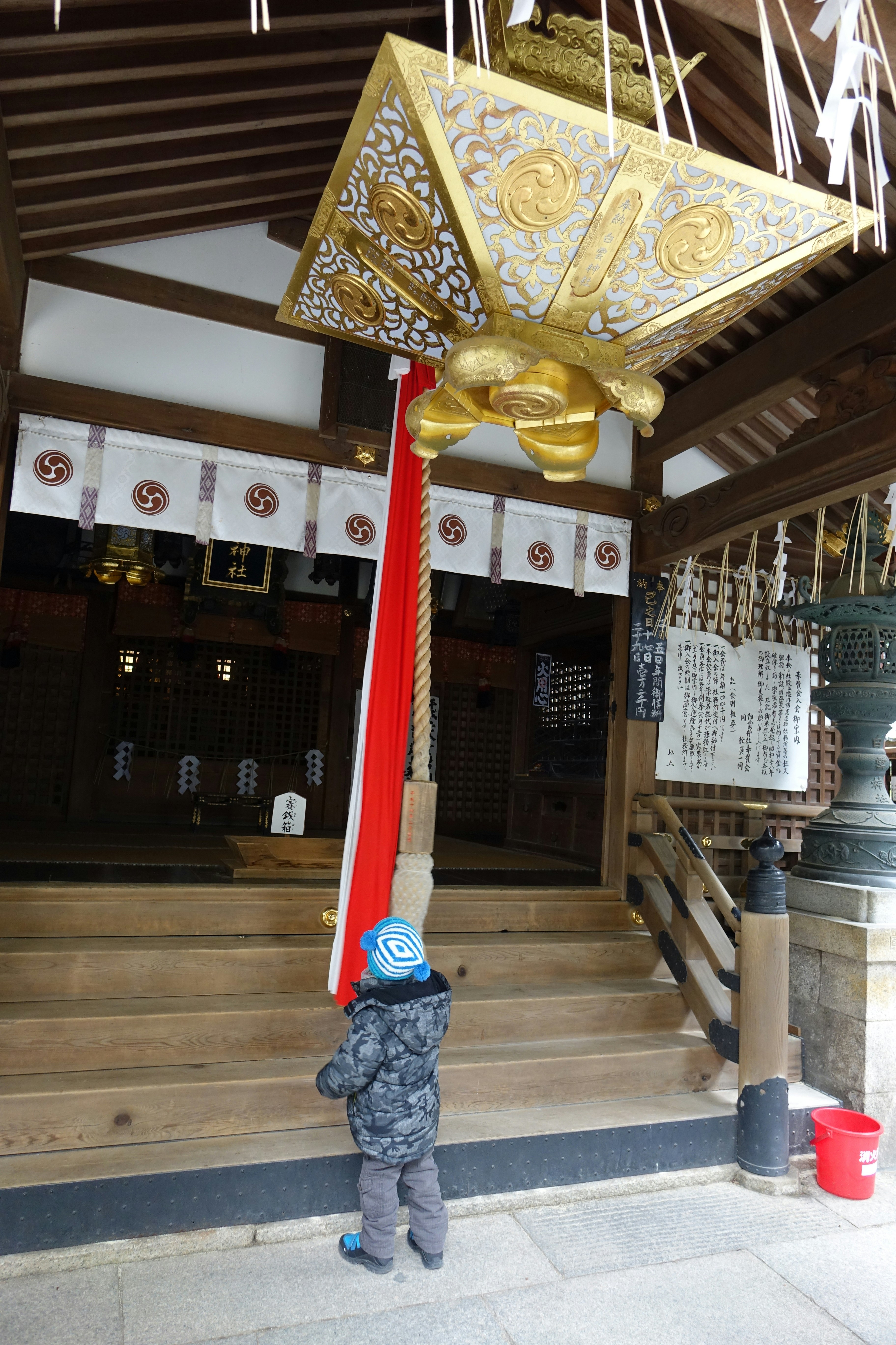 Curiosity at the Golden Lantern: A Child's Reach at a Temple Shrine