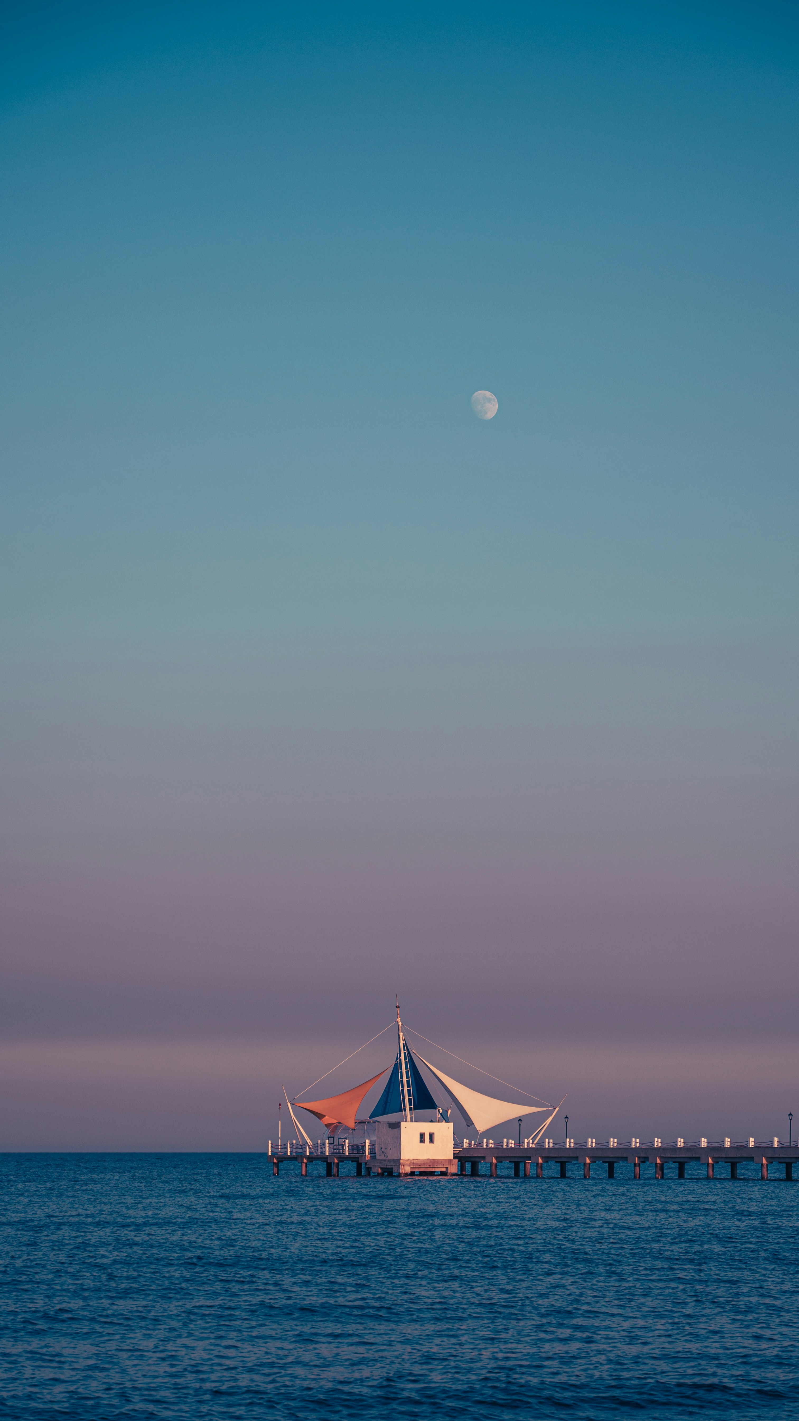 Moonlit Pier: A Calm Moment Over Blue Horizons