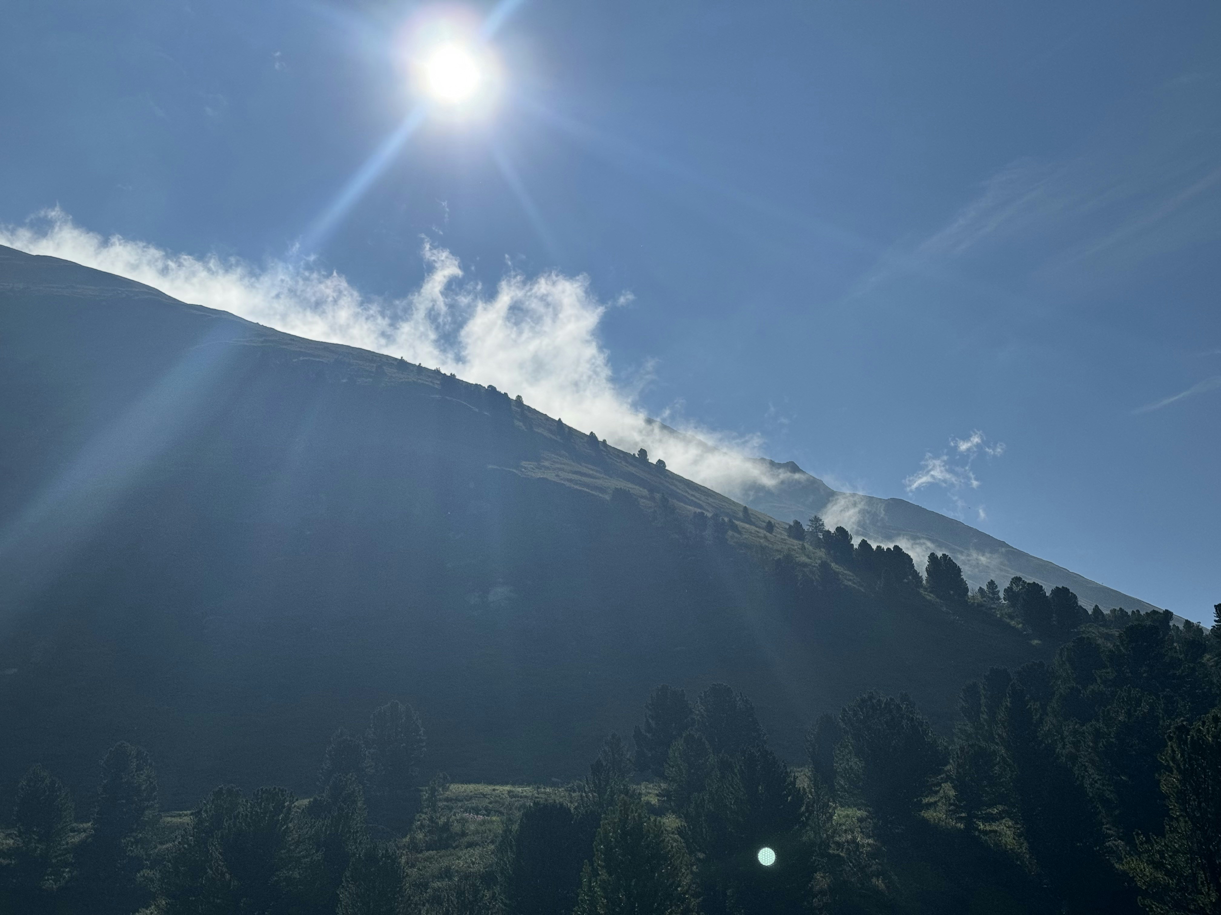 Dawn Sunbeams Spill Across a Quiet Alpine Ridge