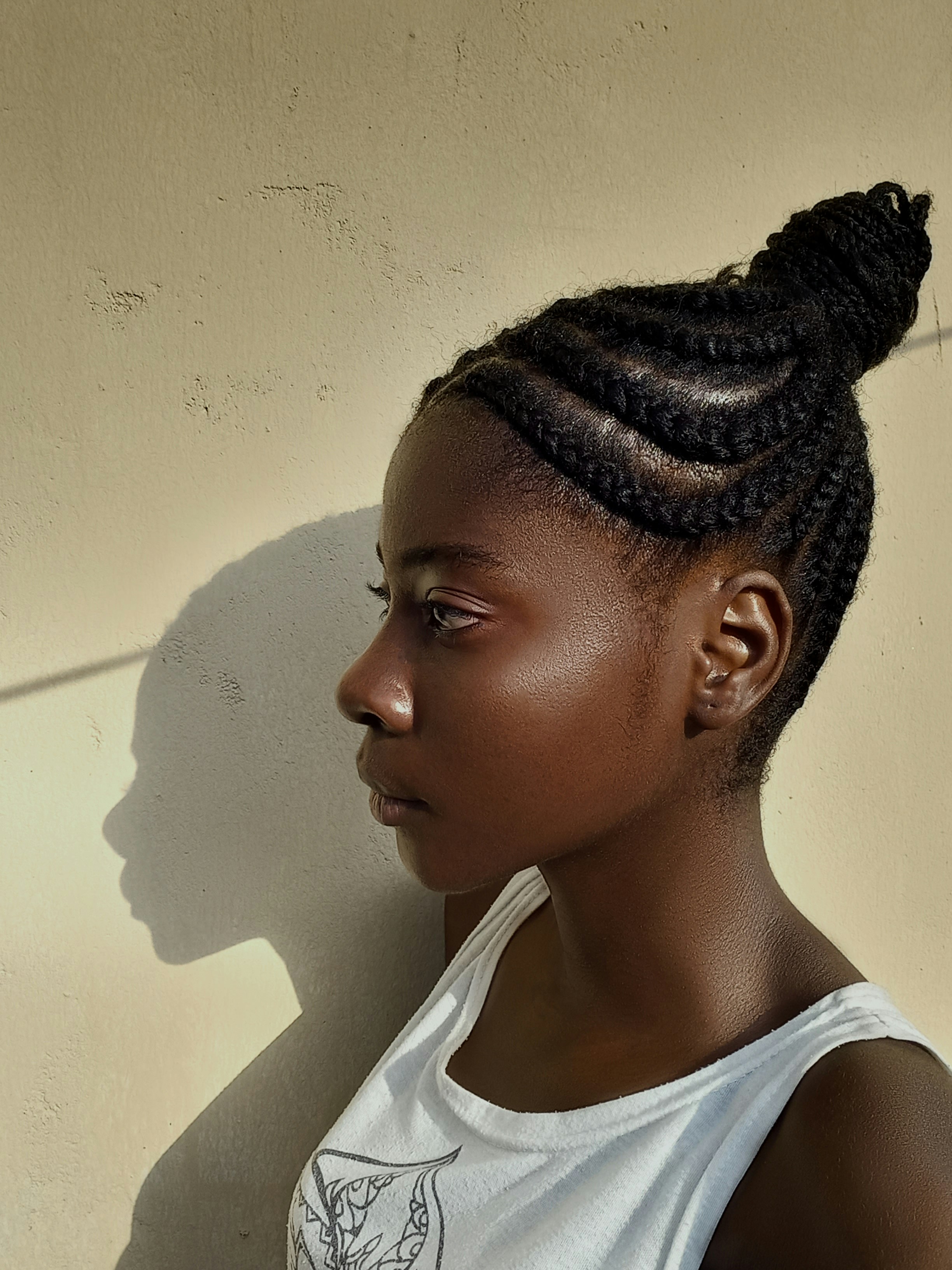 A woman with a white tank top and braids on her hair photo – Free Girl ...