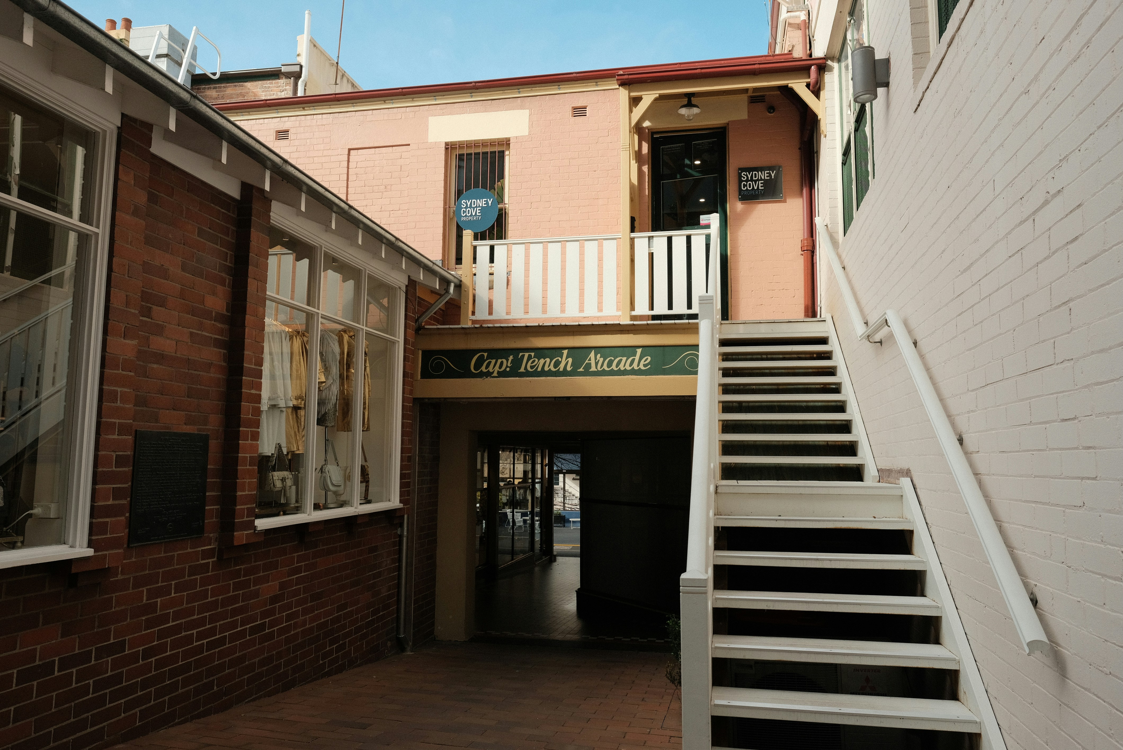 Cap't Tench Arcade: Staircase Framing a Sunlit Passage