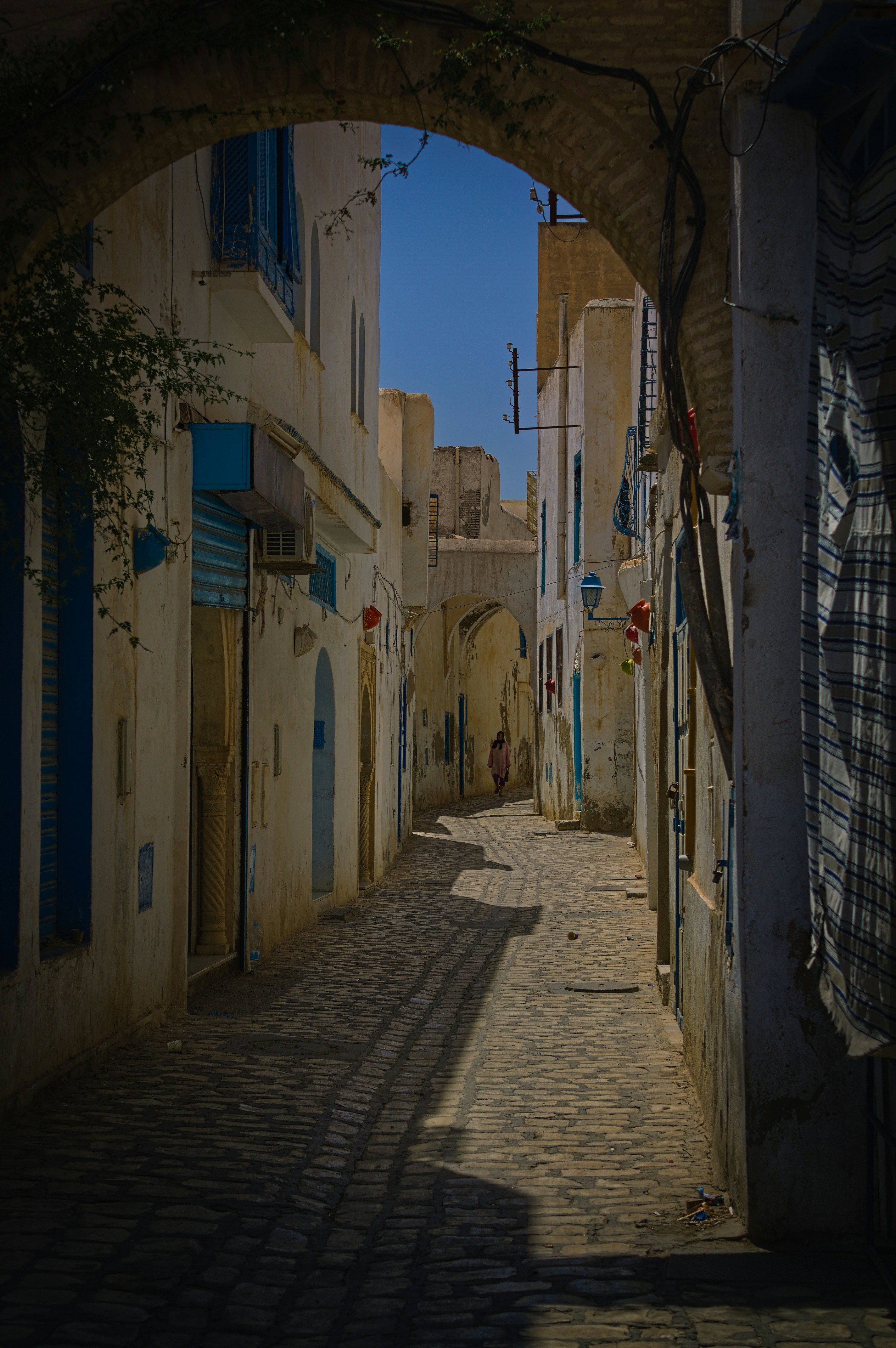 A narrow alleyway with a stone arch leading into the distance photo ...