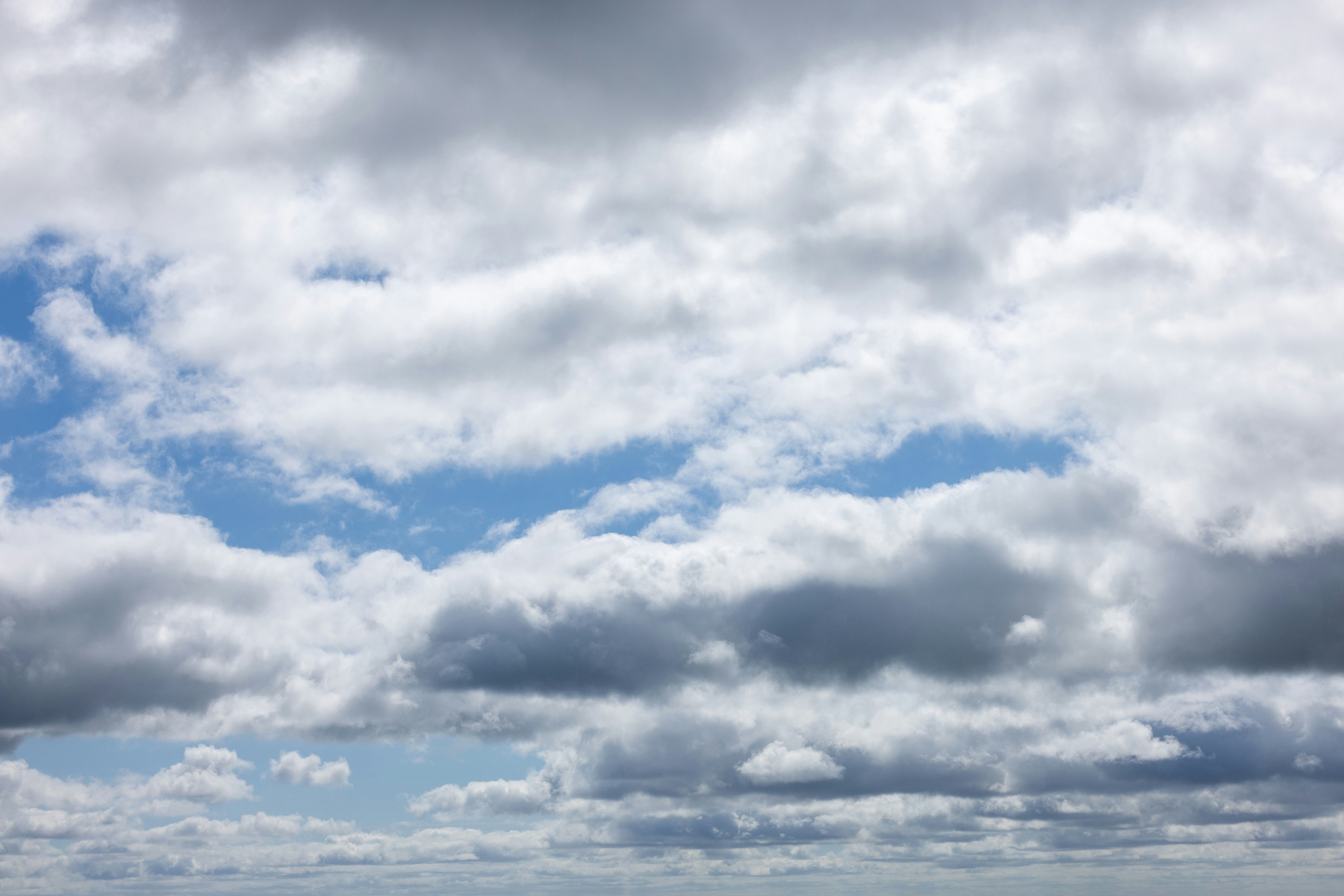 Vast expanse of clouds interspersed with patches of blue sky, creating a serene atmosphere. Ideal for showcasing the dynamic nature of weather patterns.