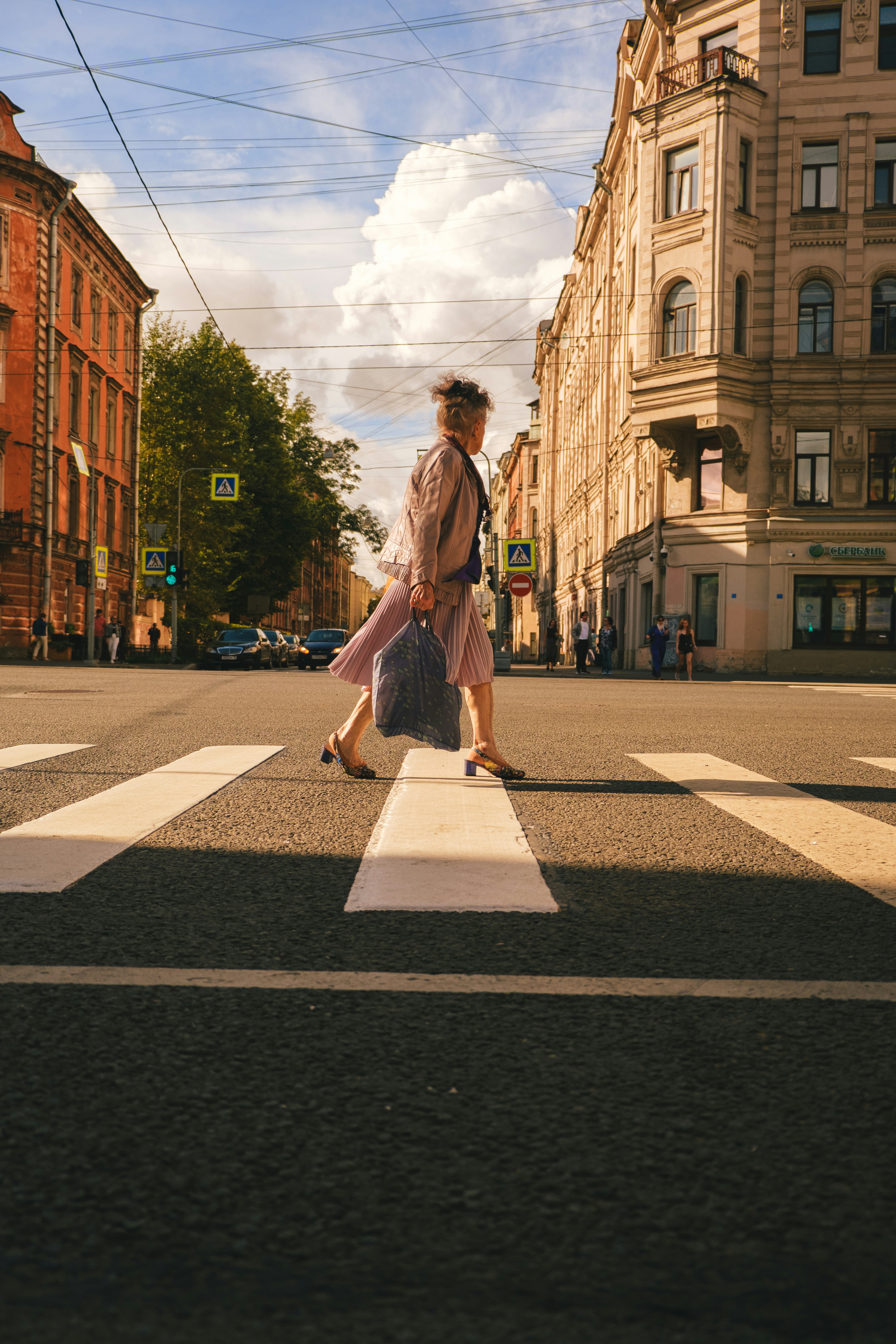 A man walking across a cross walk in the middle of a street photo ...