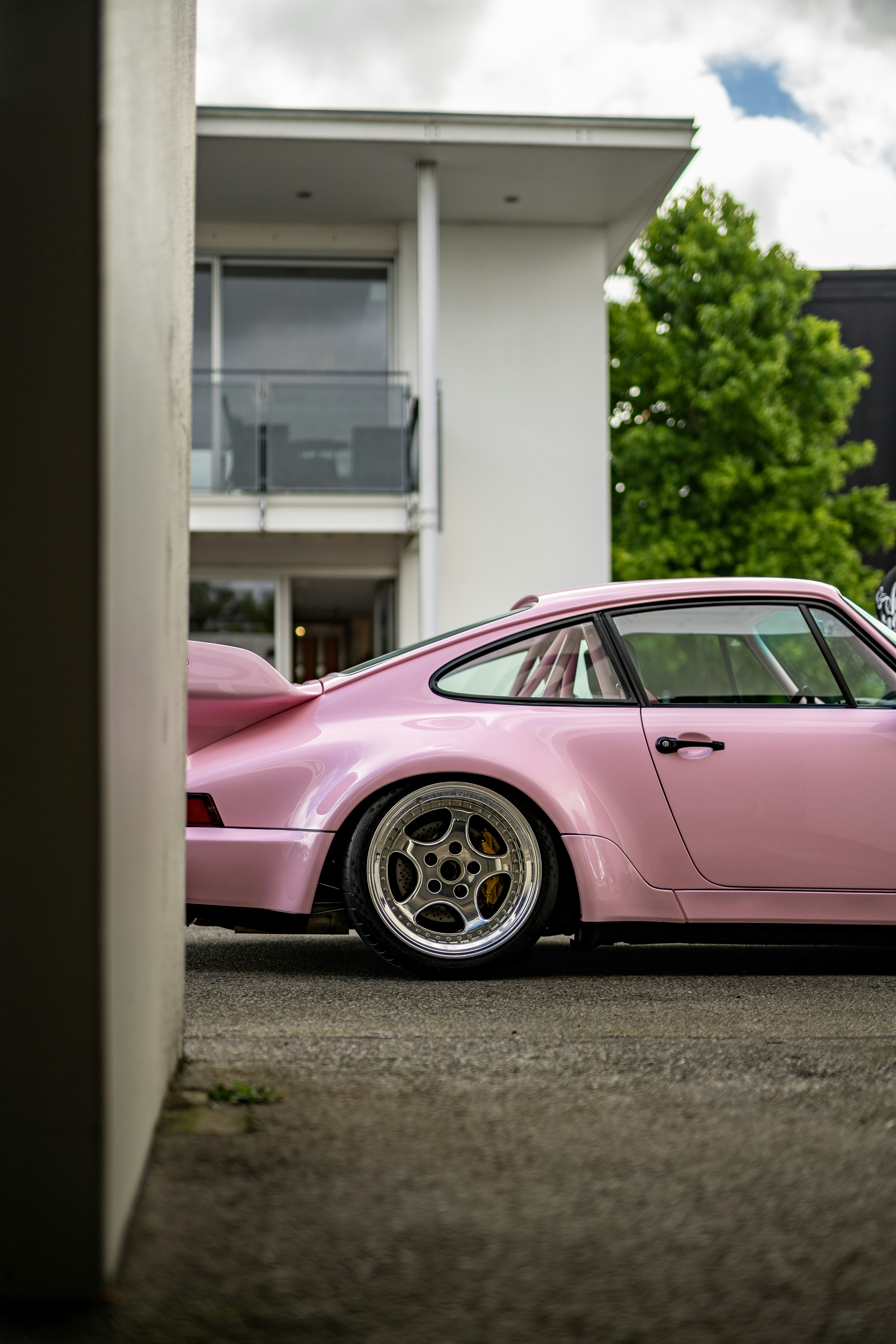 A pink porsche parked in front of a building photo – Free Car Image on ...