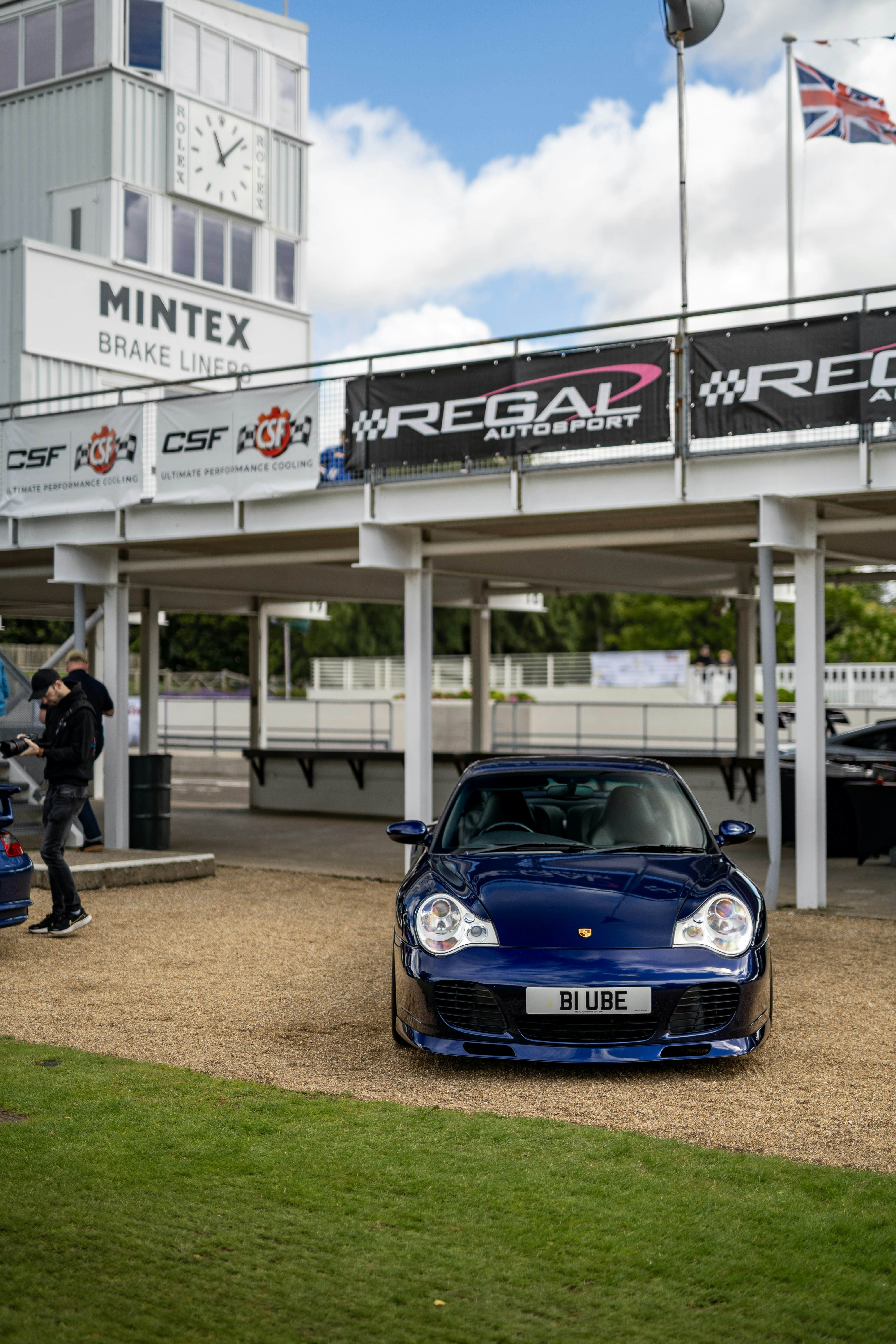 Blue Porsche on Display Under Racing Pavilions