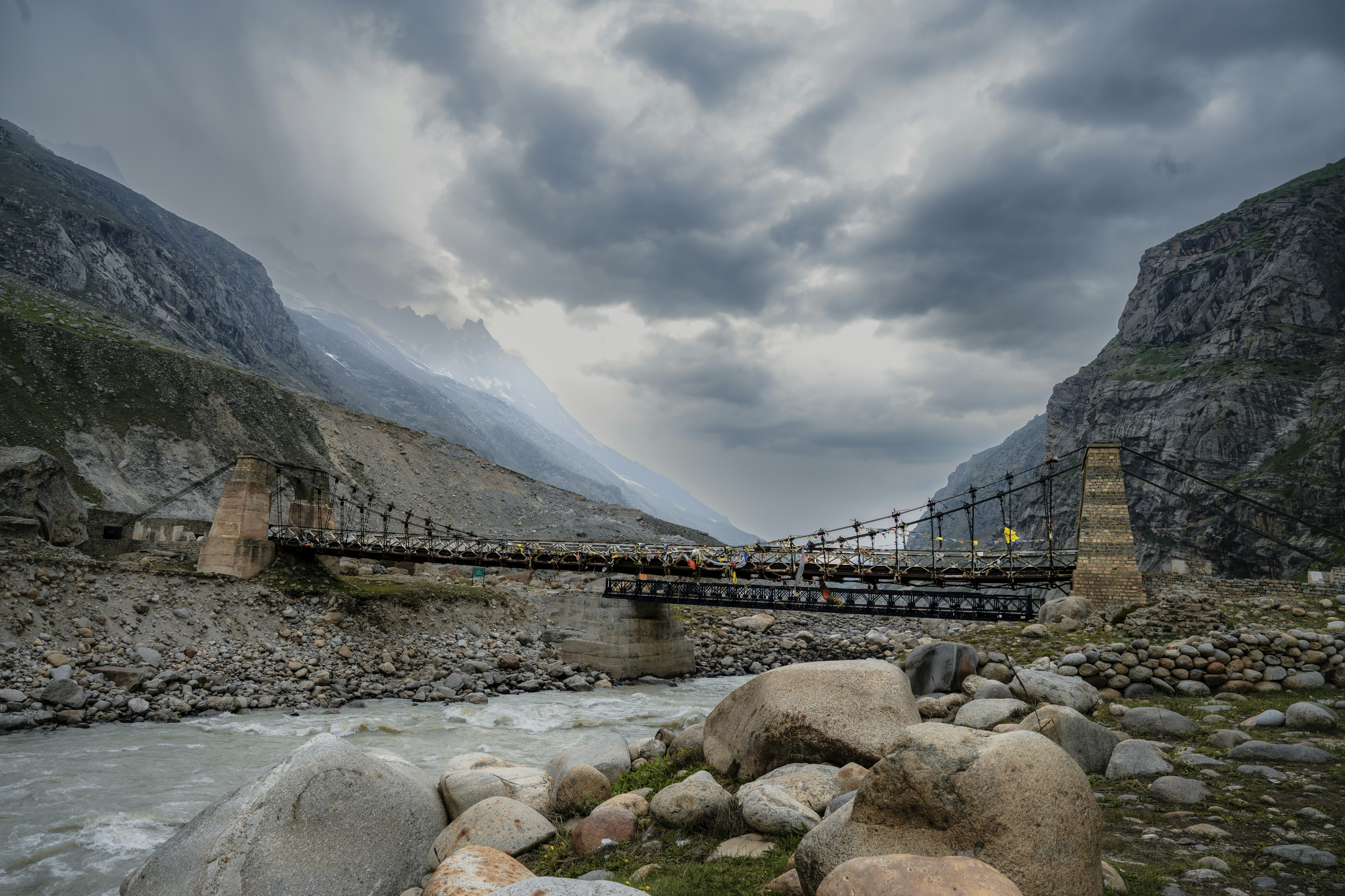 A river with rocks and a bridge in the background photo – Free Rock ...