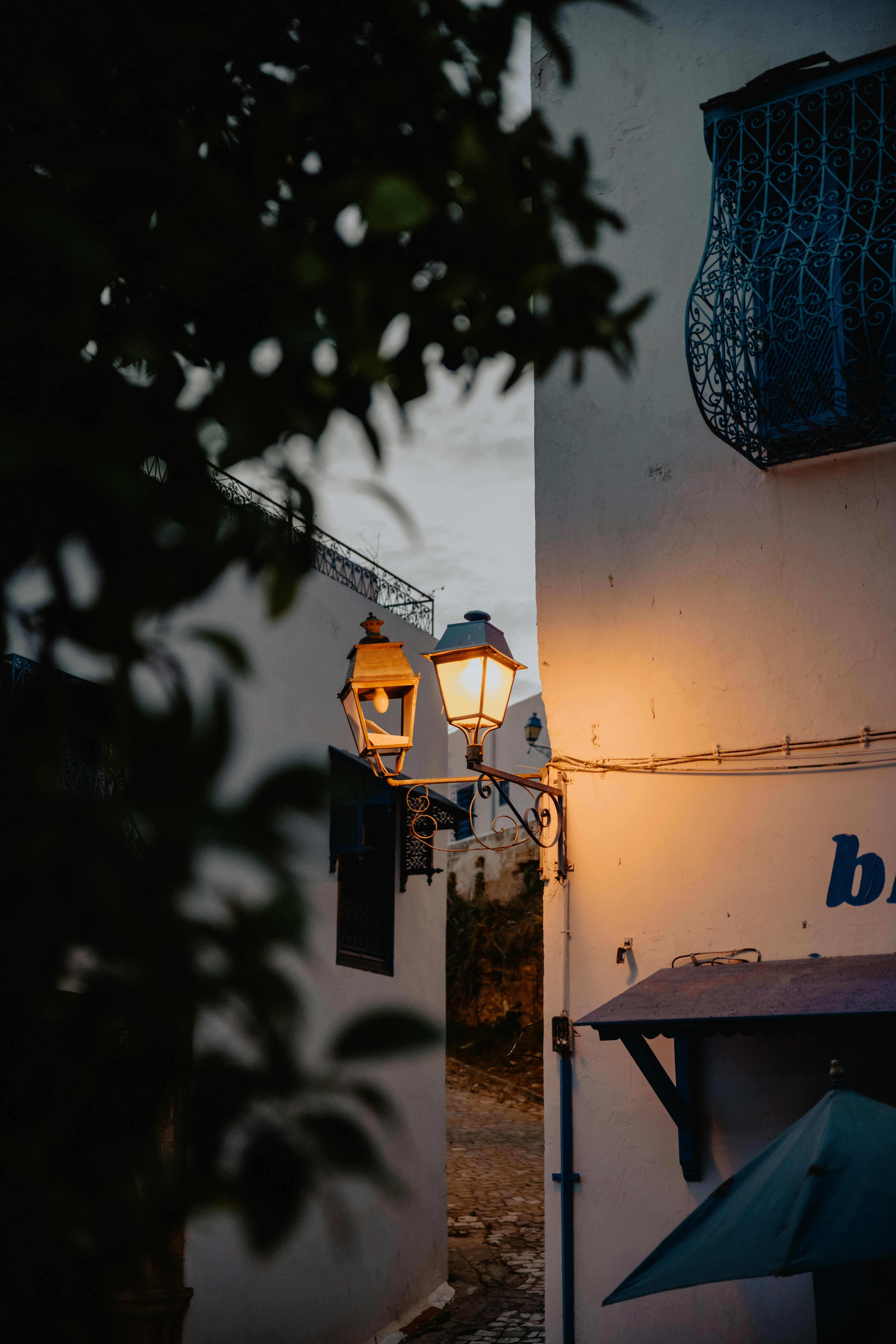 Lanterns in a Quiet Alley: Warm Light on White Walls