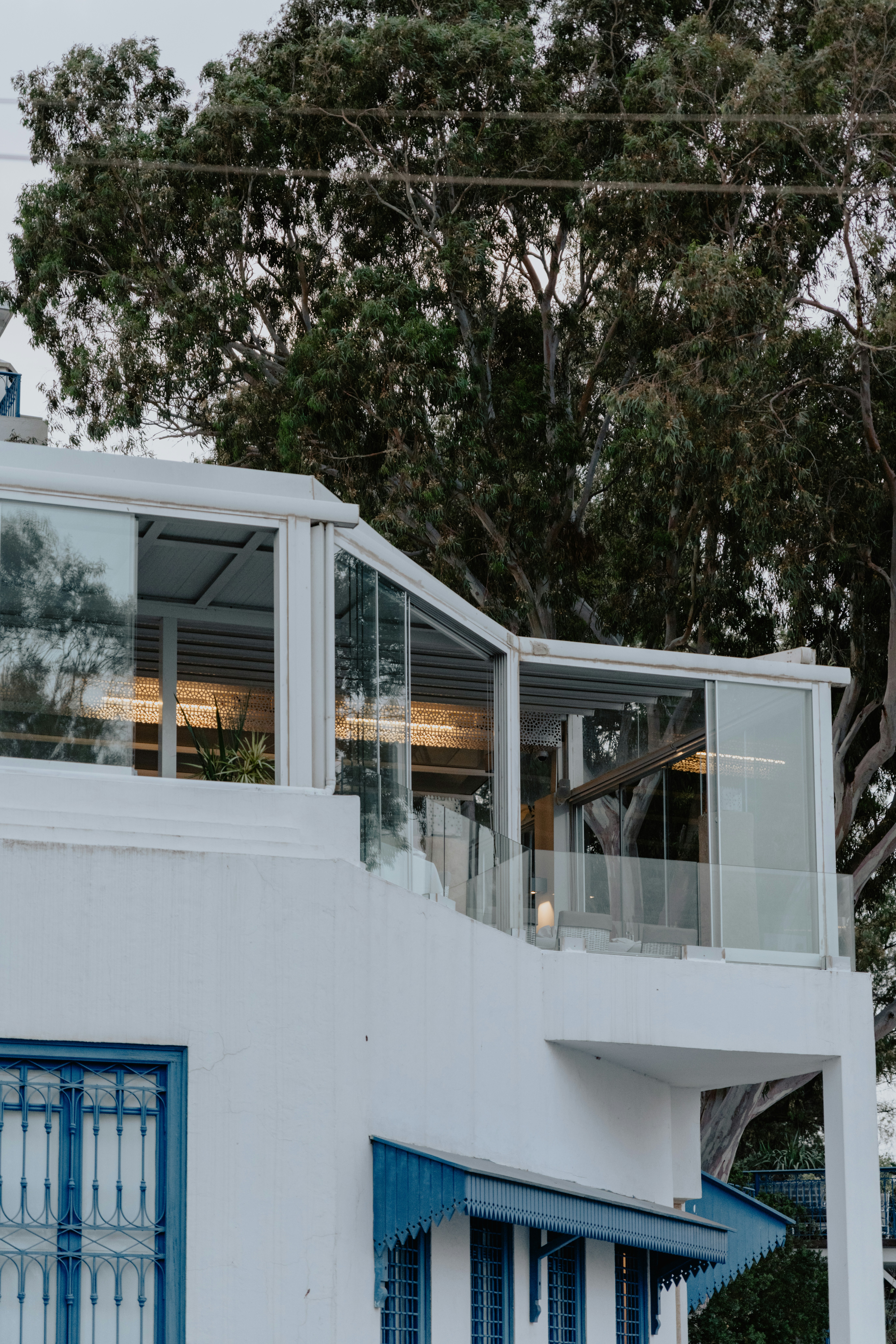 A white building with blue shutters and a balcony