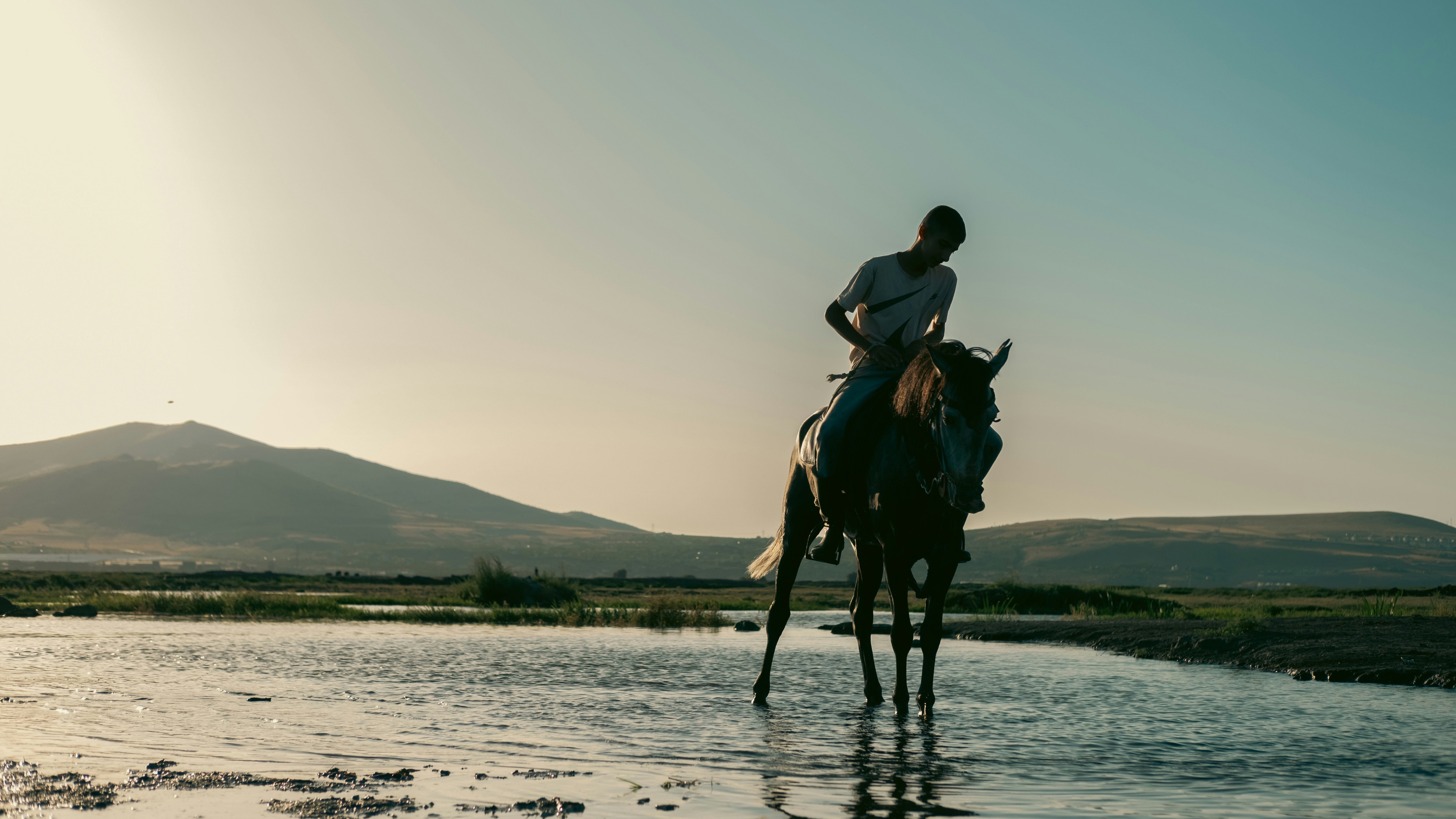 A person riding a horse across a body of water photo – Free Wallpaper ...