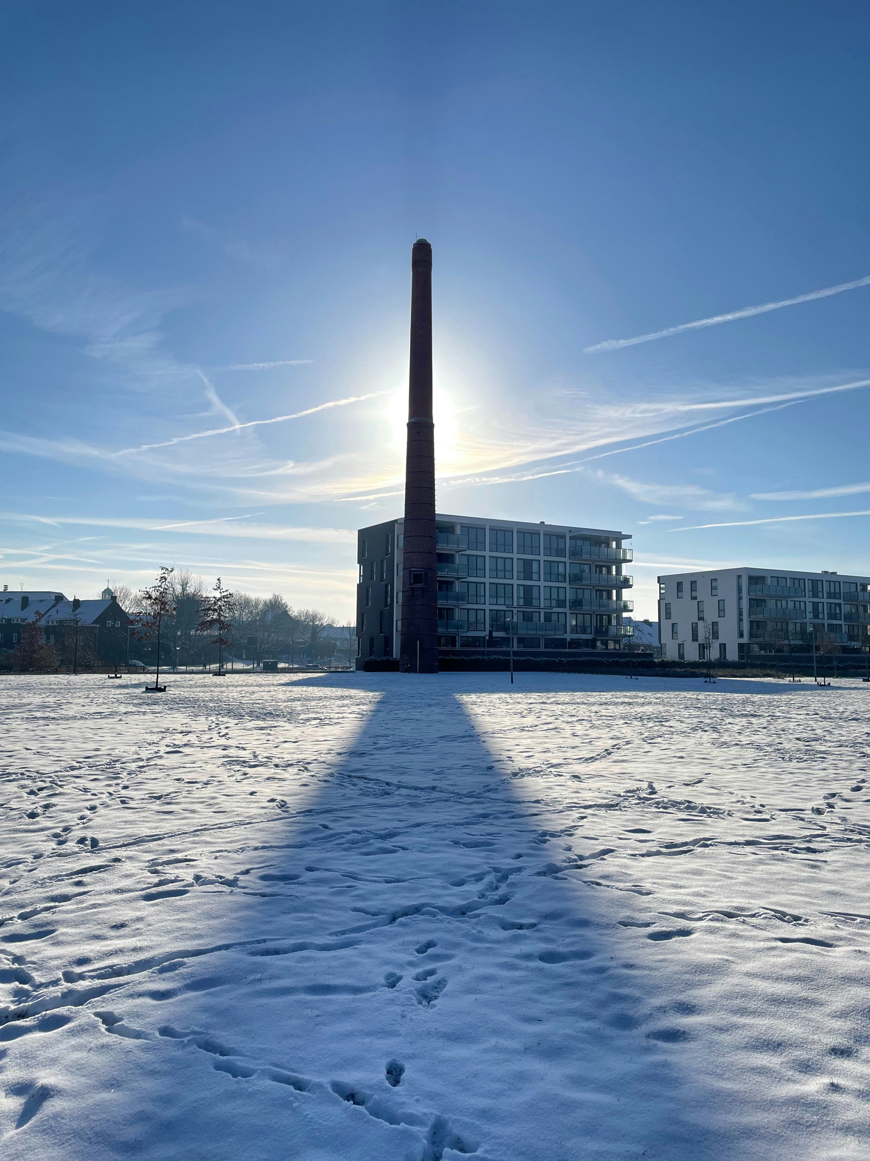 Sunburst Behind a Central Chimney Casts a Dramatic Shadow Across Snow