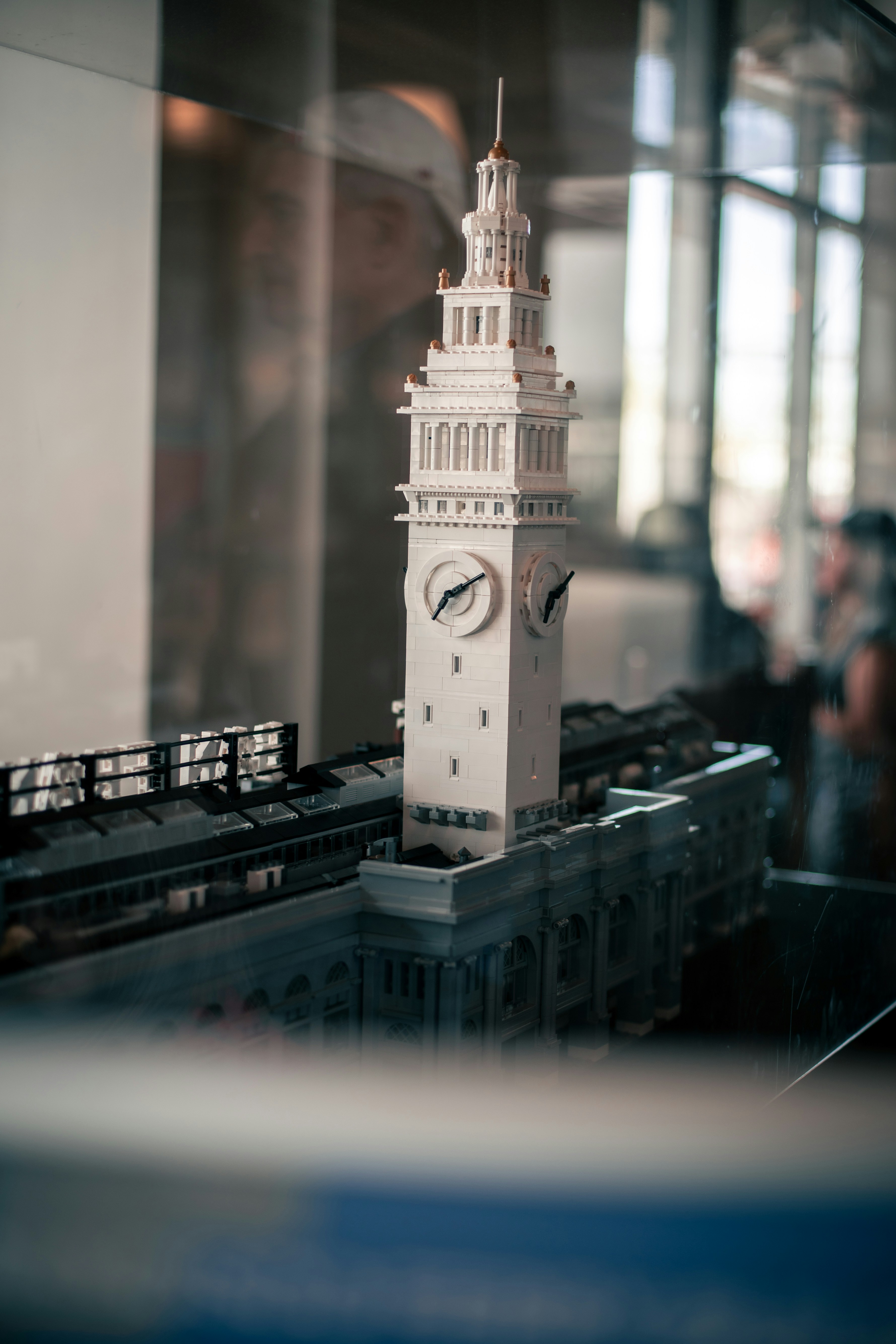 Tower in Miniature: A Clock Tower Model Beneath Glass Reflections
