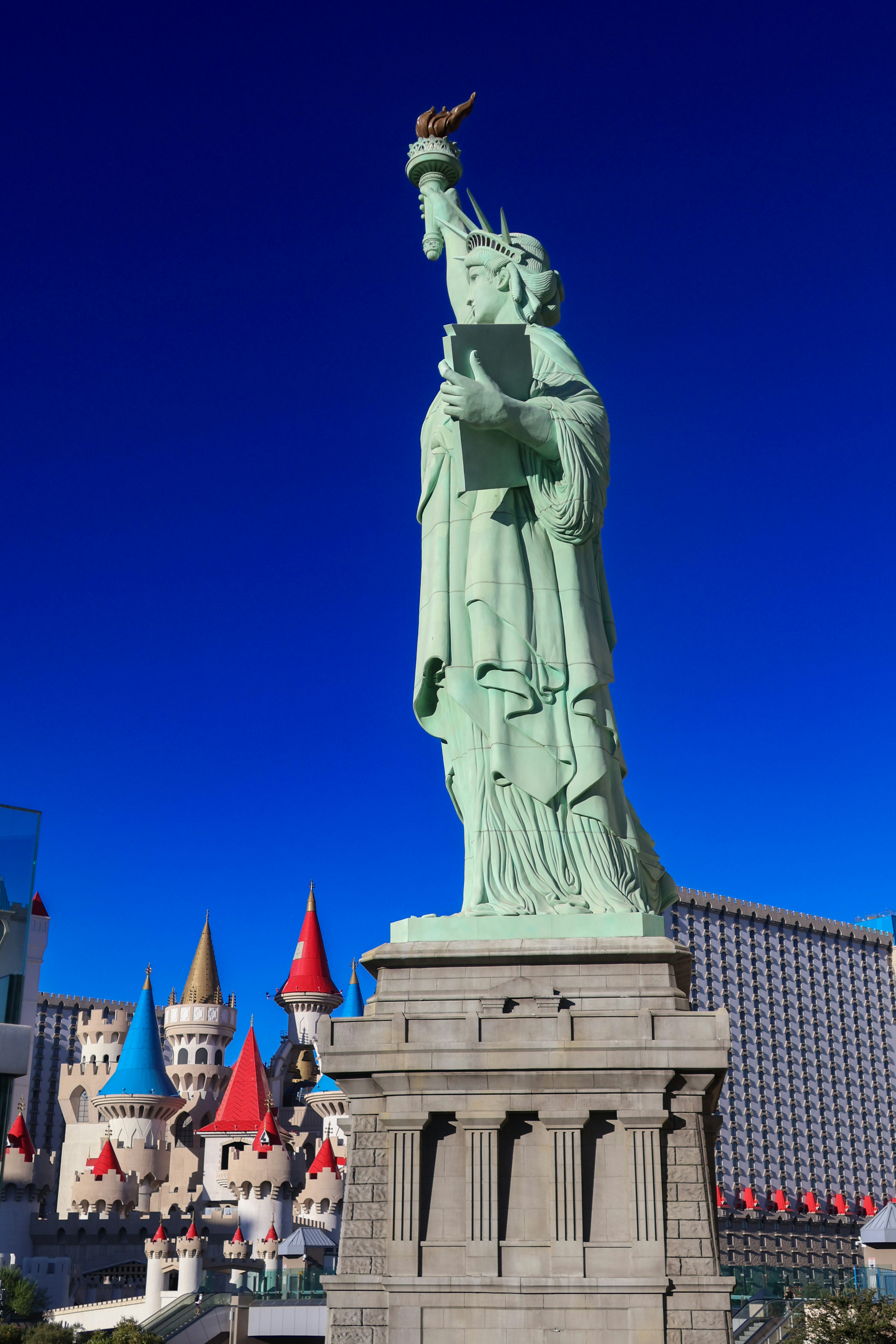 Azure Sky, Minted Liberty: A Vegas Strip Statue of Liberty Rises Over Colorful Castles